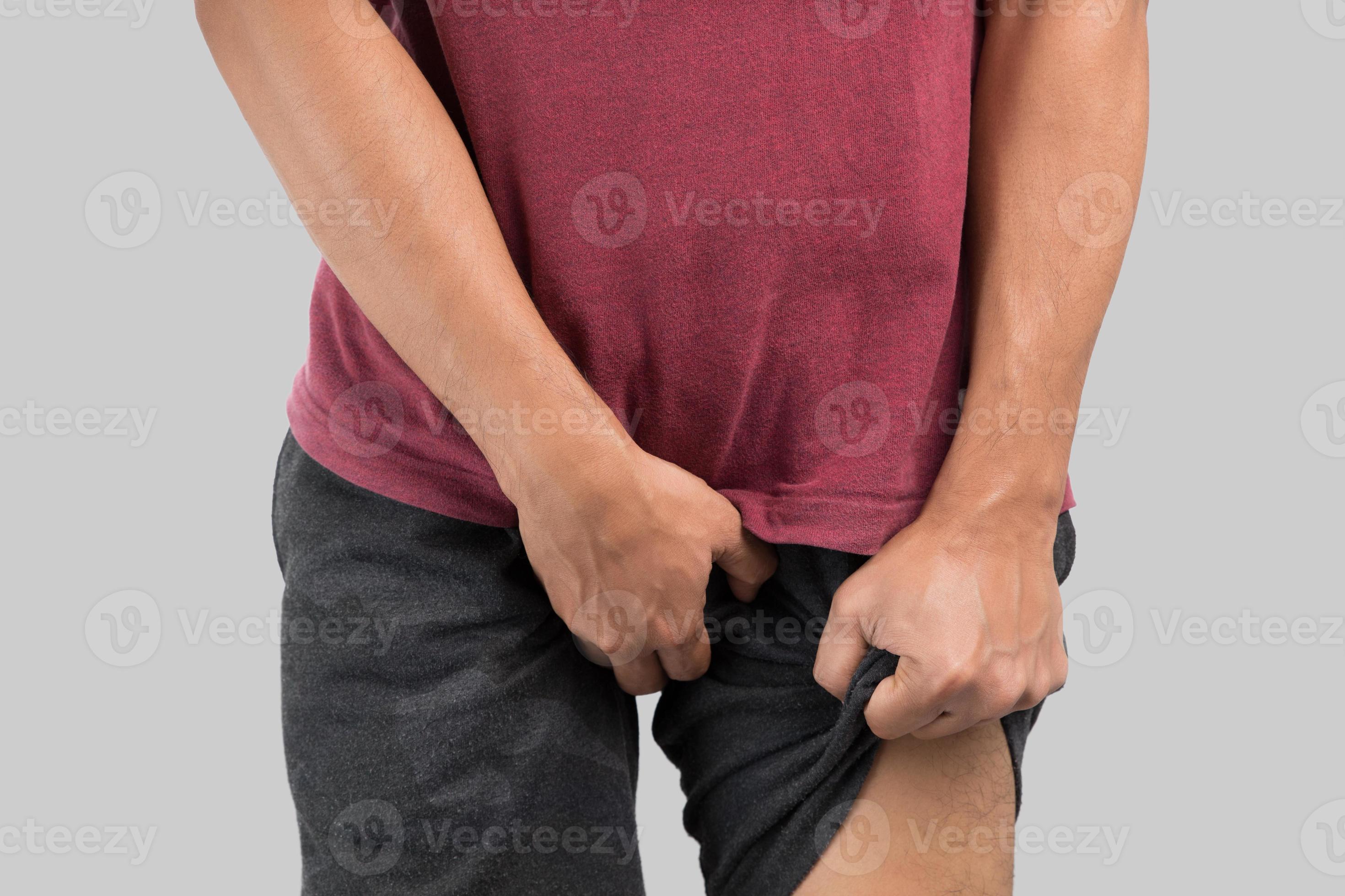 Asian men grab or cover his crotch because wanting to urinate against gray background. 20223011 ...