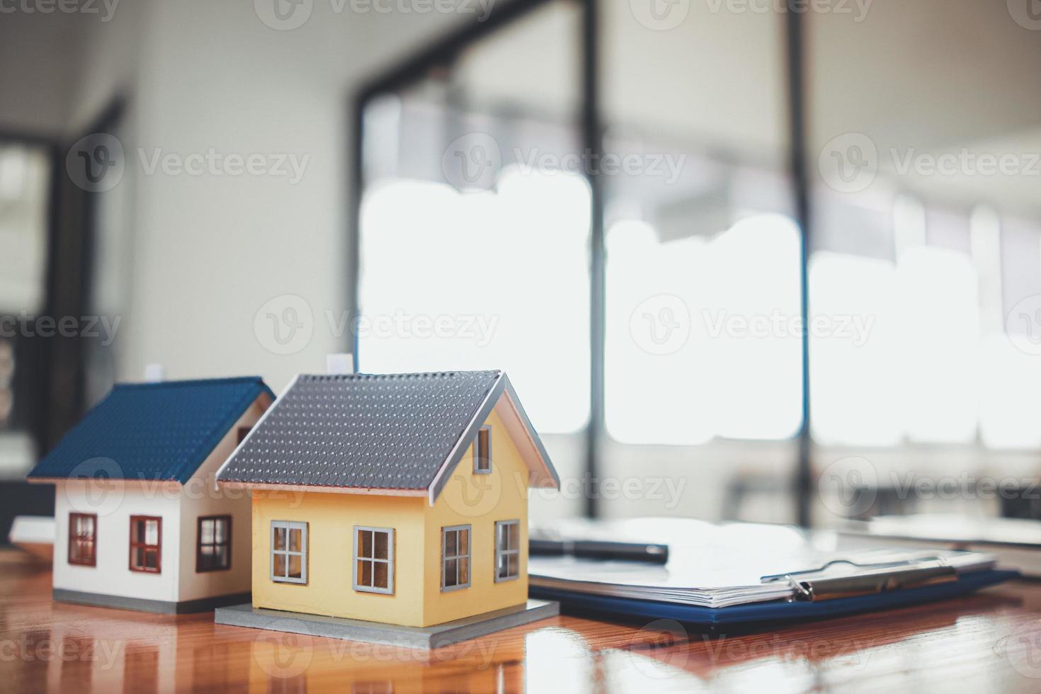 Real estate sales documents and model homes are placed on tables inside real estate sales ...