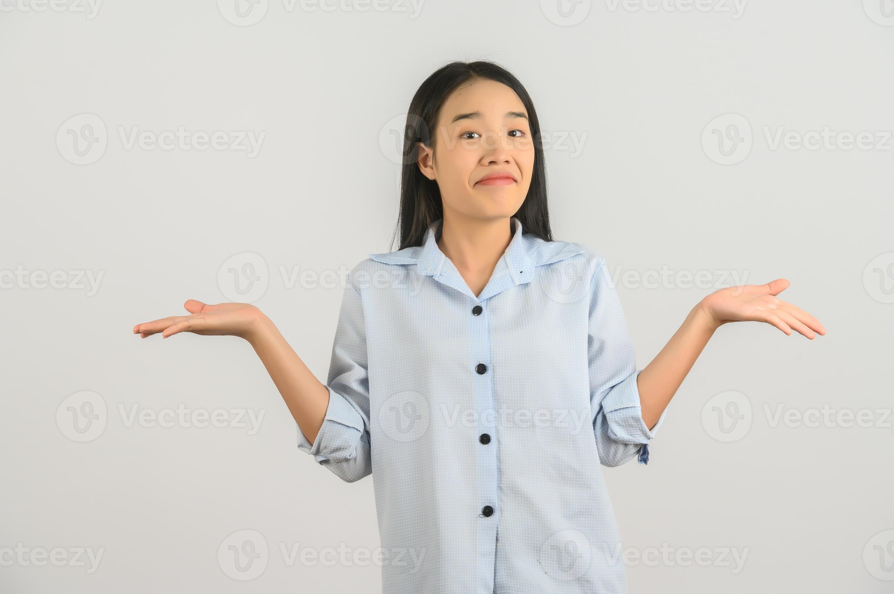 Portrait of confused young asian woman in blue shirt shrugging ...