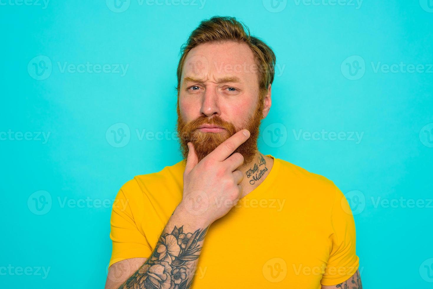 Man With Yellow T Shirt And Beard Is Very Undecided 20554498 Stock