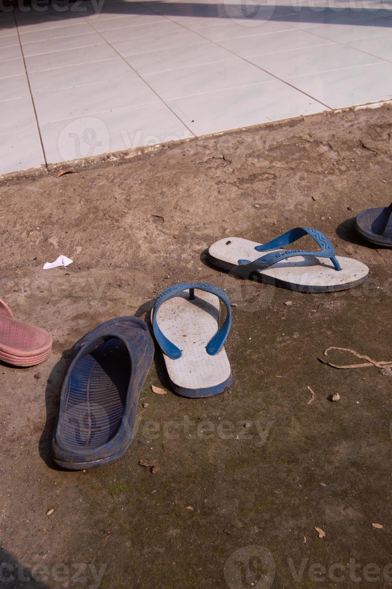 worn sandals scattered on the ground 20823125 Stock Photo at Vecteezy