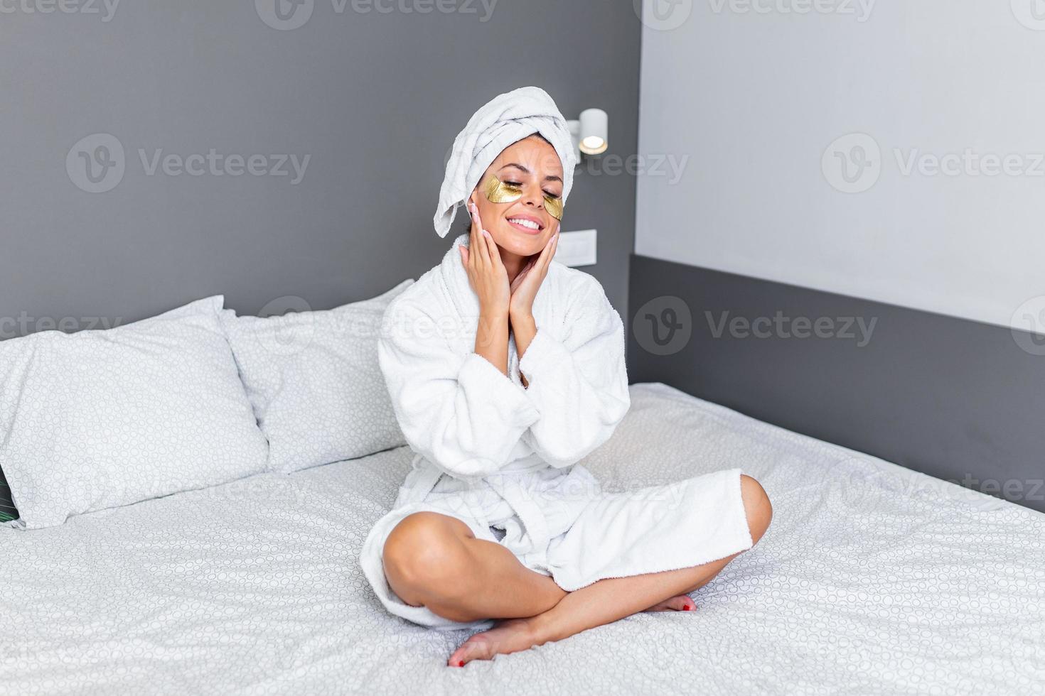 Beautiful Girl In Bathrobe Is Touching Her Face With Gold Cosmetics