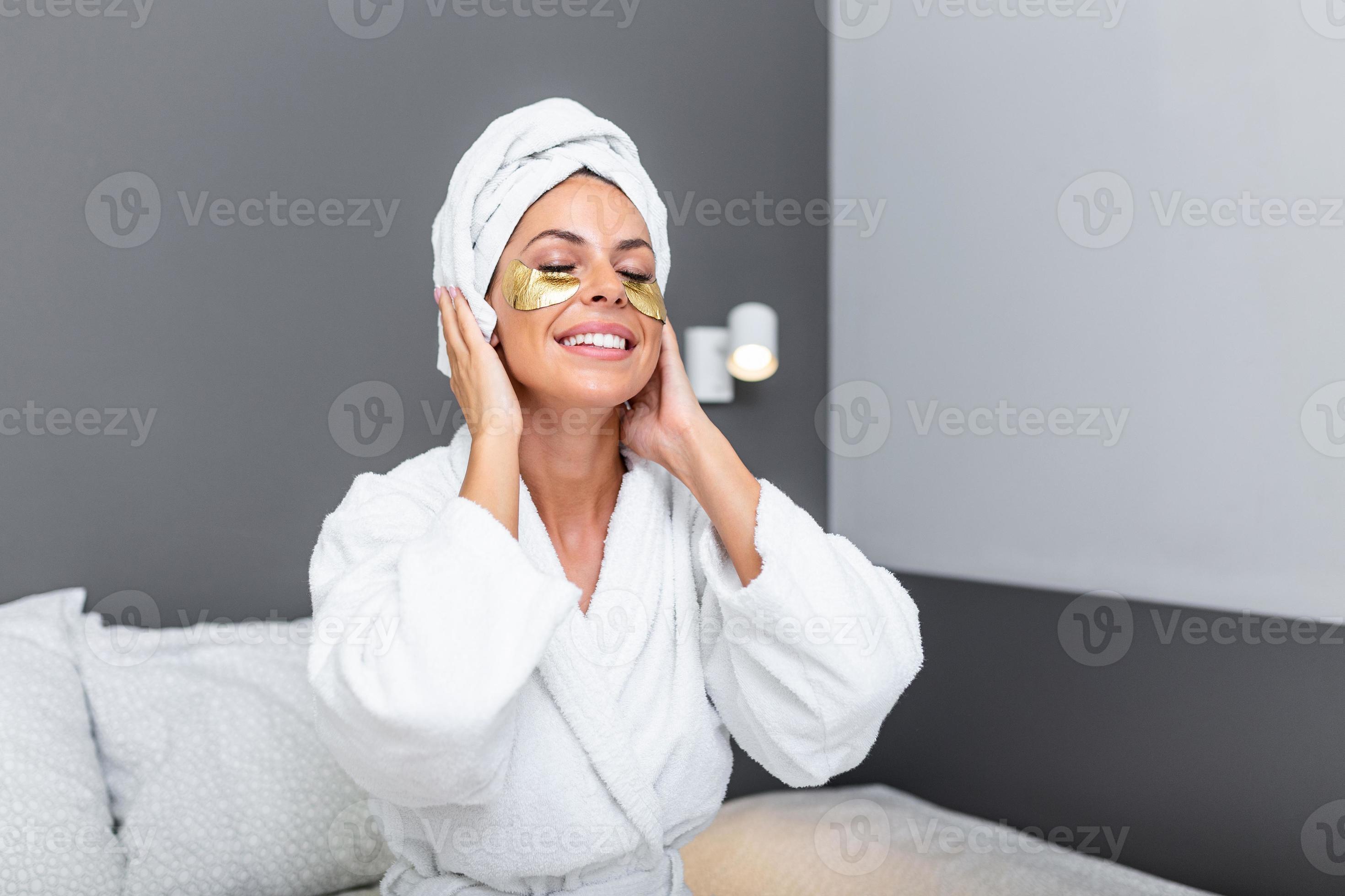 Beautiful Girl In Bathrobe Is Touching Her Face With Gold Cosmetics