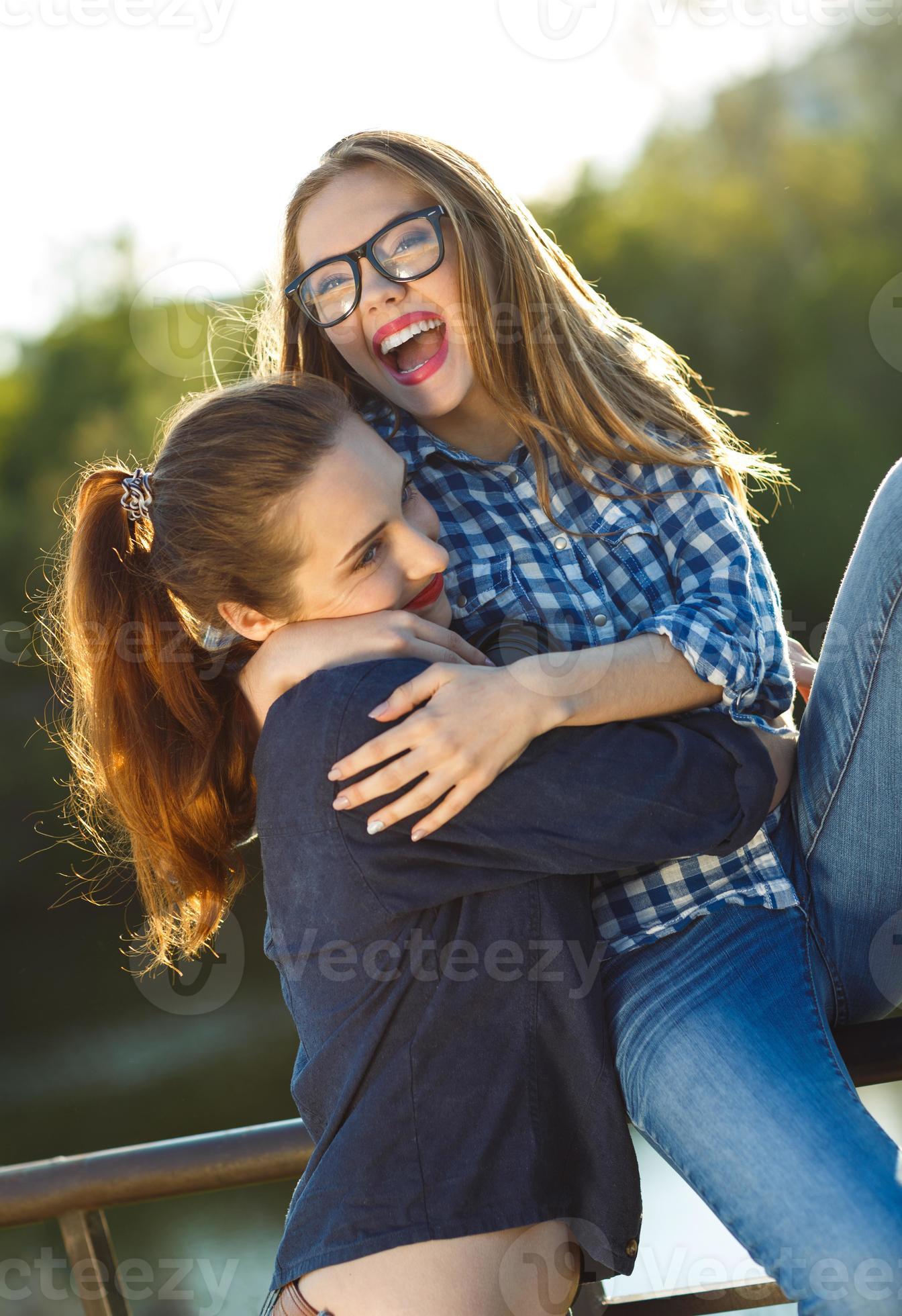 Two playful young women having fun outdoors 21144461 Stock Photo at Vecteezy