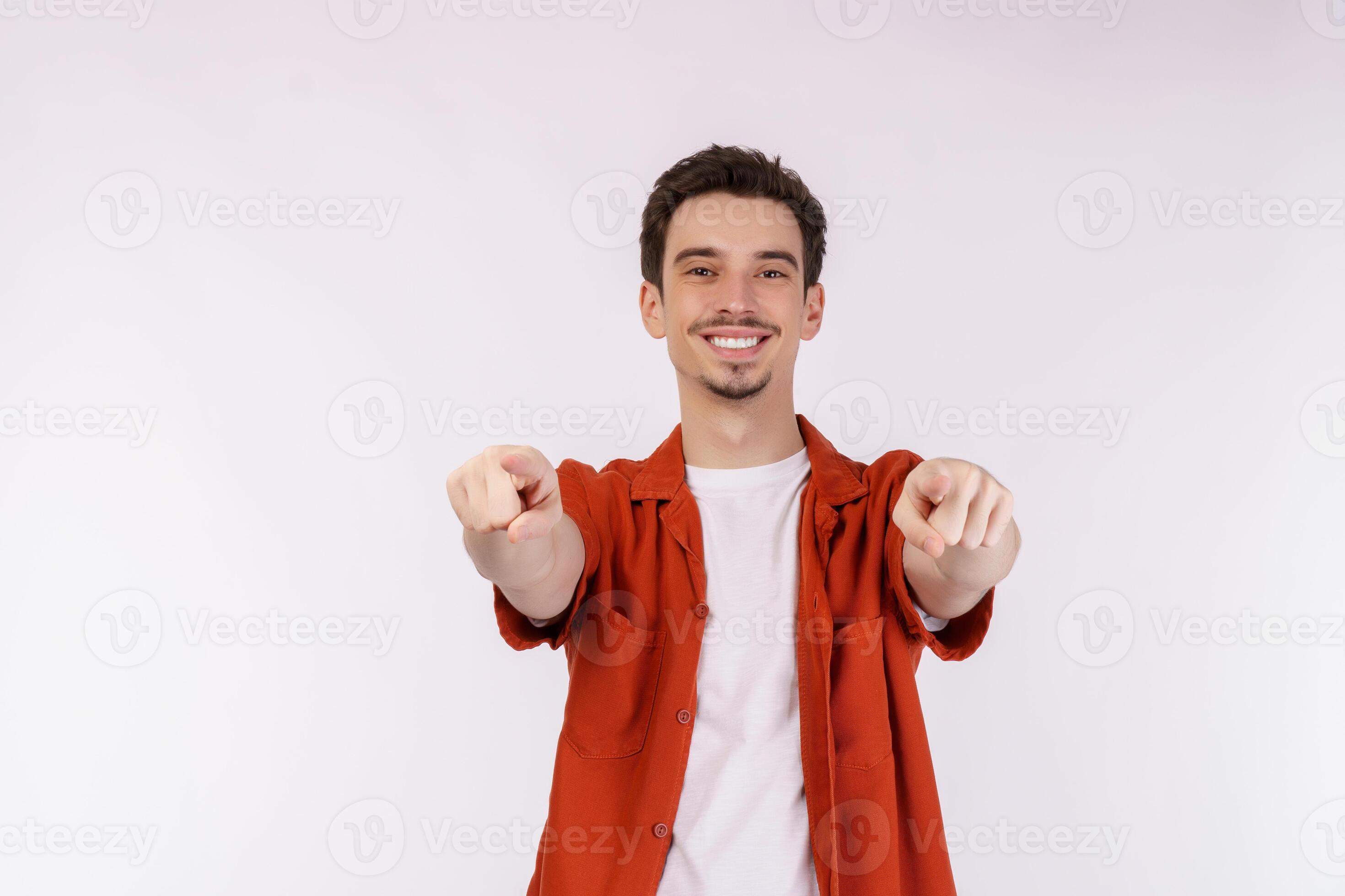 Portrait of attractive cheerful young man pointing finger at camera and ...