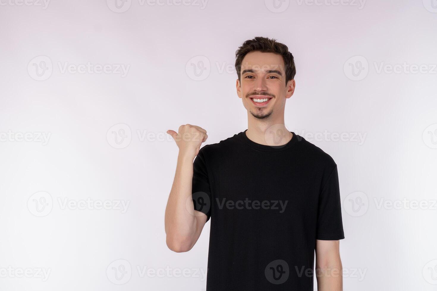 Portrait of young man pointing fingers at copy space isolated on white ...
