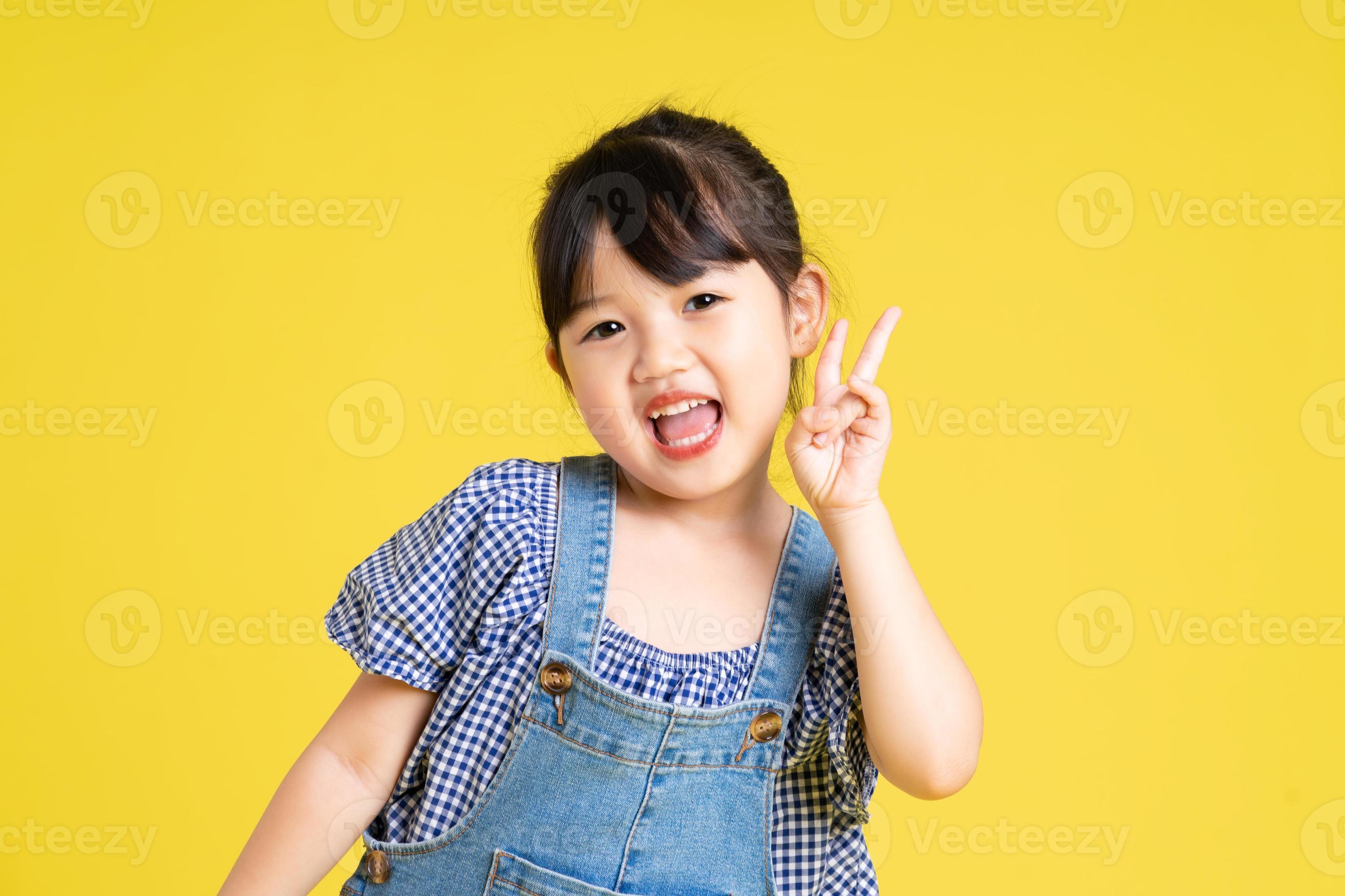 Portrait Of A Beautiful Asian Girl Isolated On Yellow Background