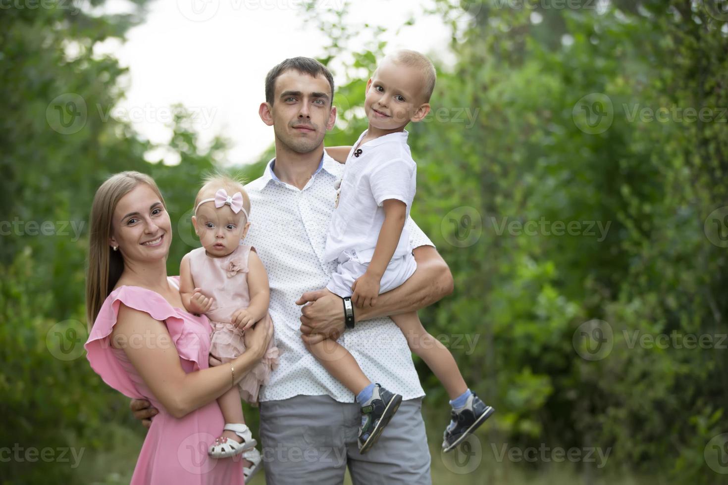 Husband and wife and their little children. Family portrait in nature ...