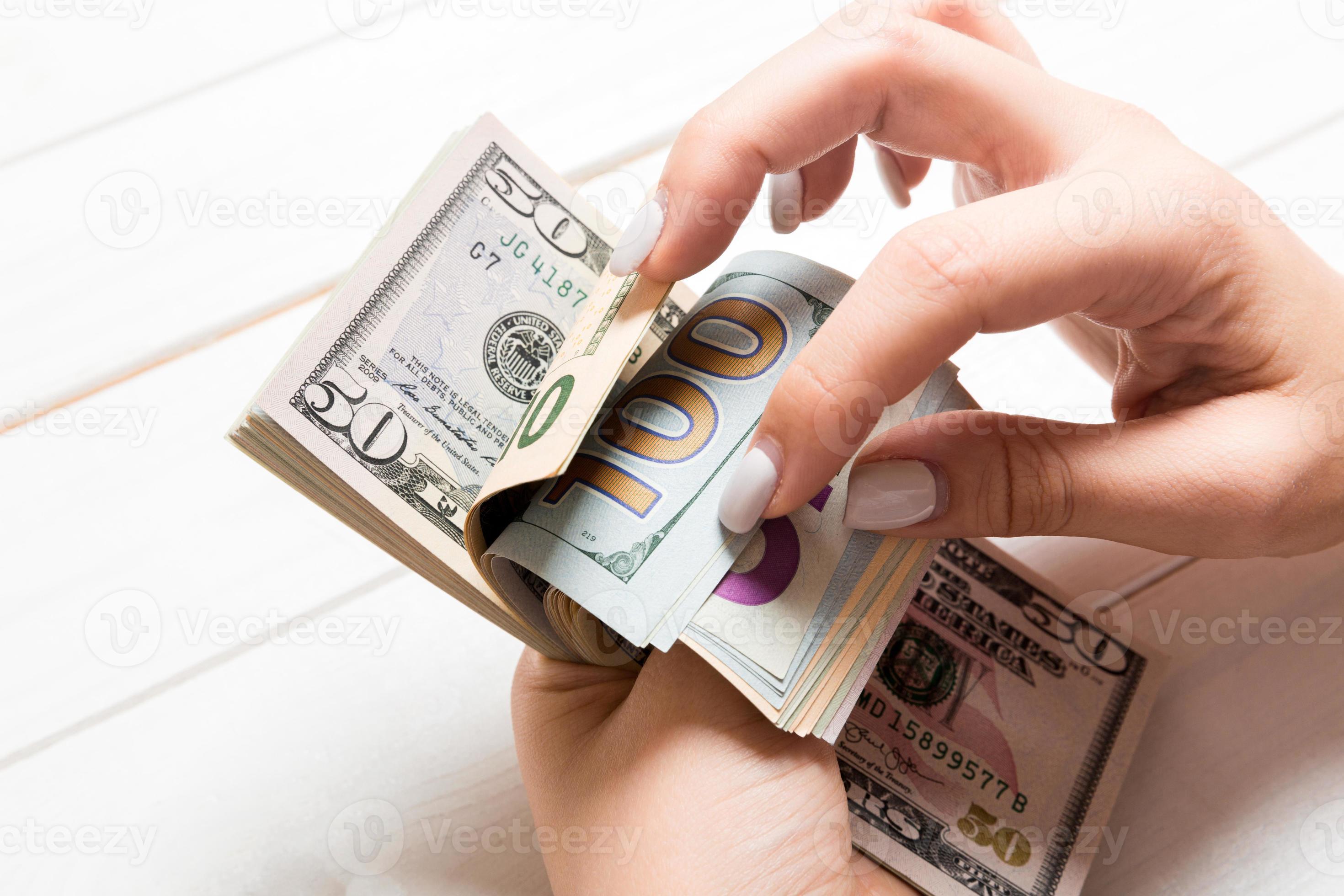 Perspective view of female hands counting money. One hundred and other ...
