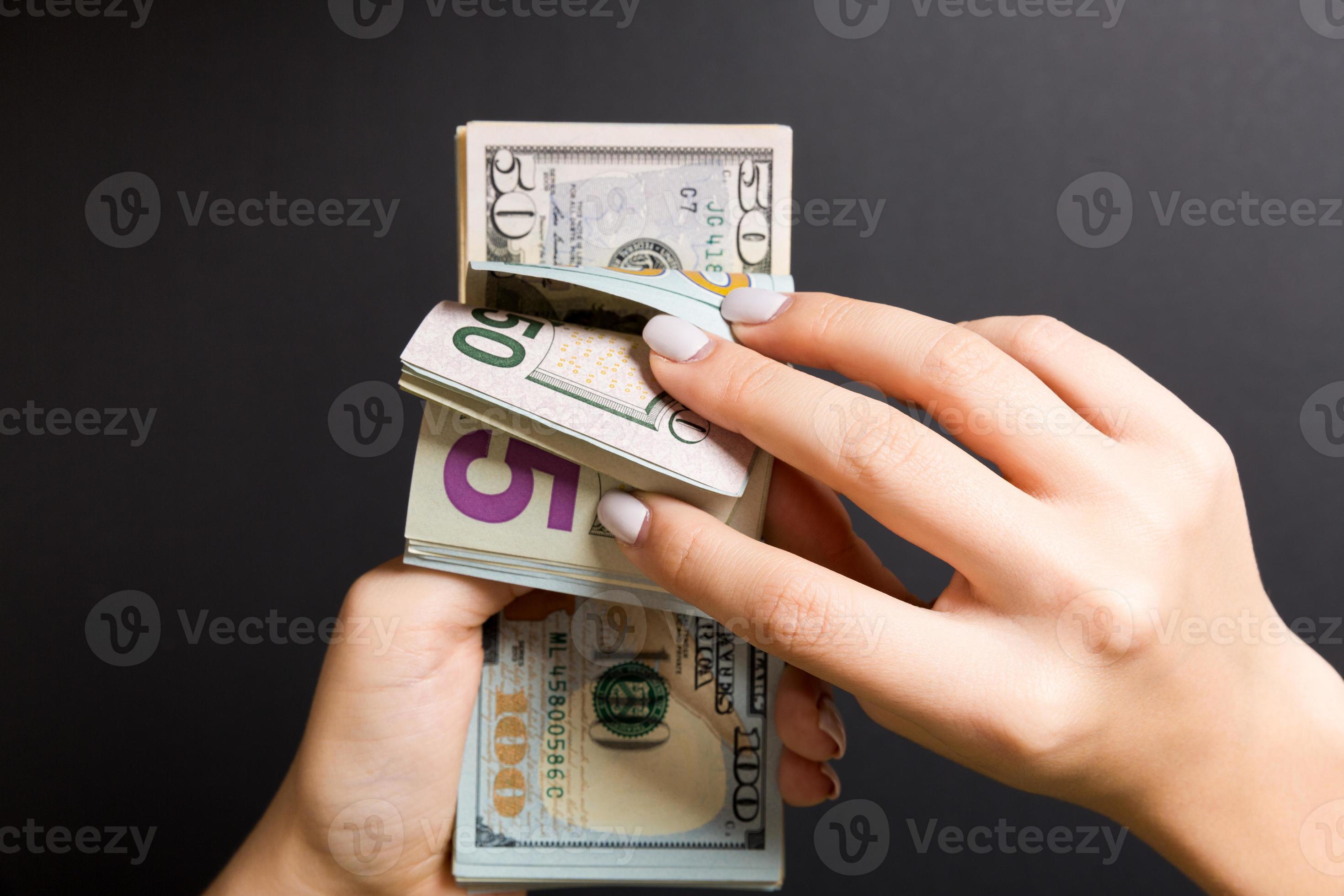 Top view of female hands counting money. One hundred and other dollar ...