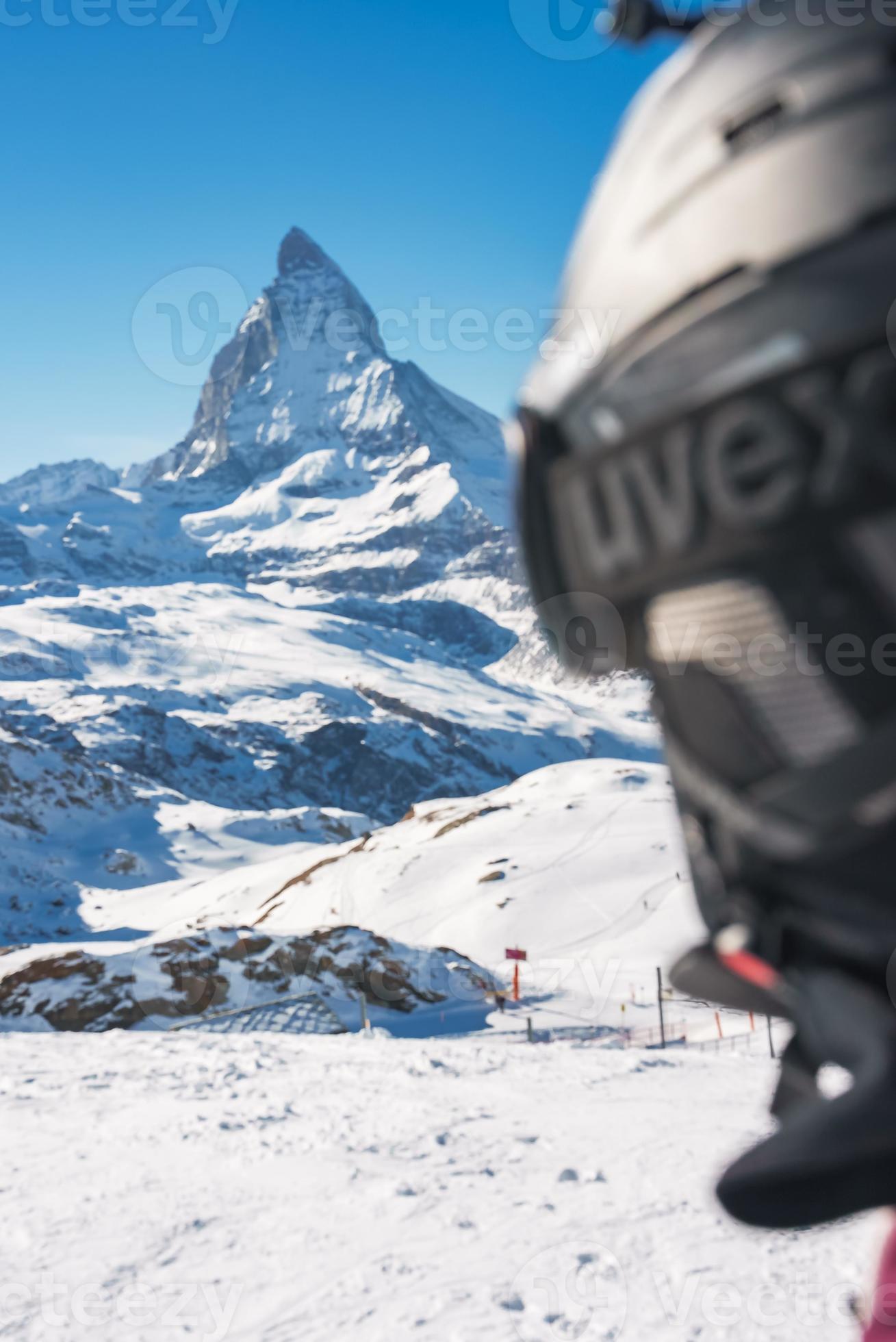 Young skier enjoying Zermatt ski resort. Beautiful sunny day with a ...