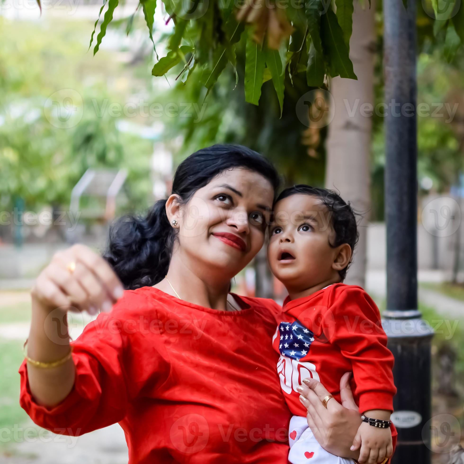 Loving mom carrying of her baby at society park. Bright portrait of happy mum holding child in ...