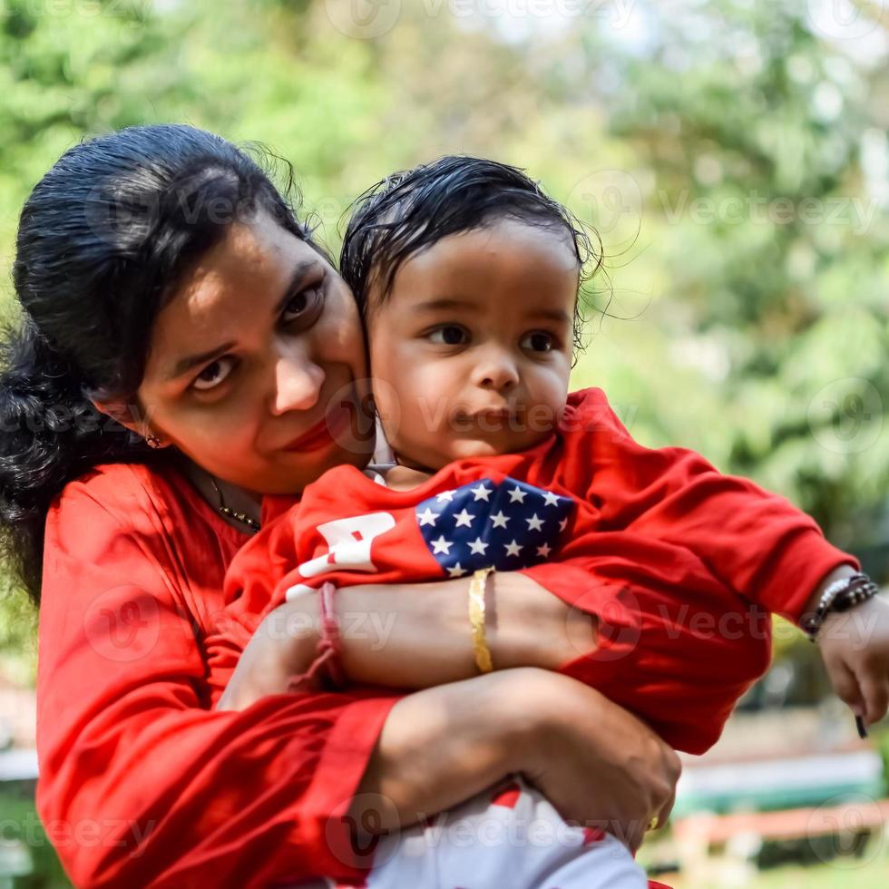 Loving mom carrying of her baby at society park. Bright portrait of happy mum holding child in ...