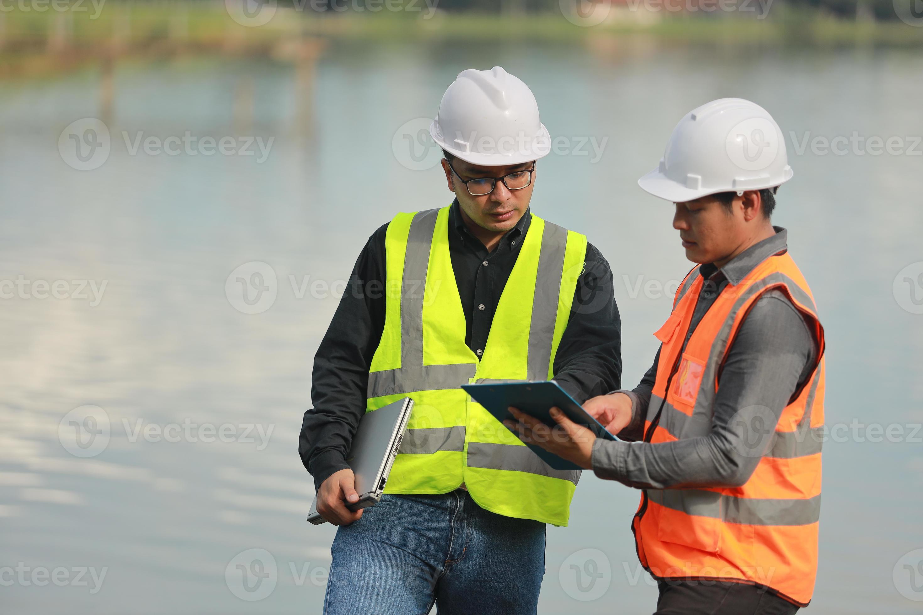 Environmental engineers work at water source to check for contaminants ...