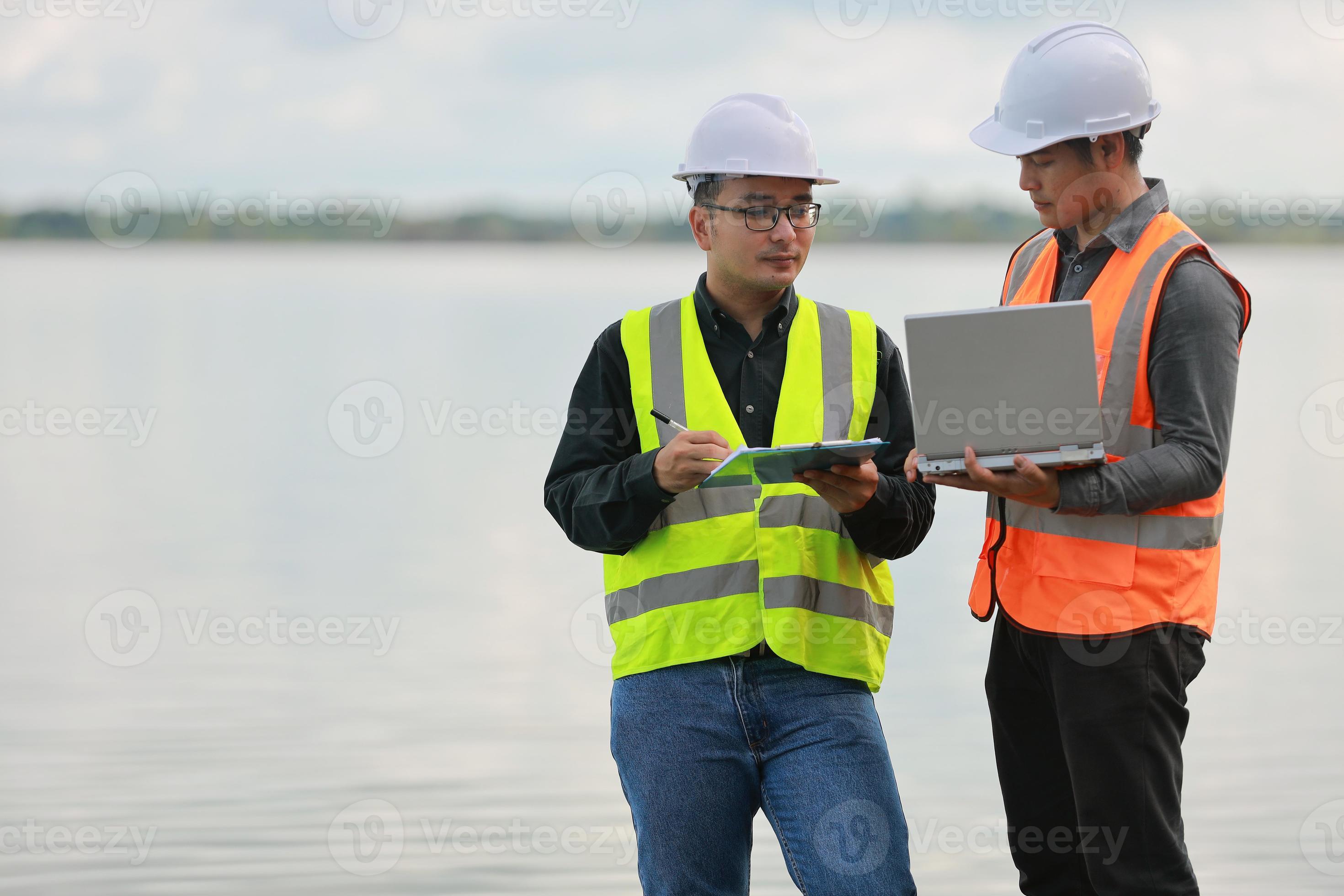Environmental engineers work at water source to check for contaminants ...
