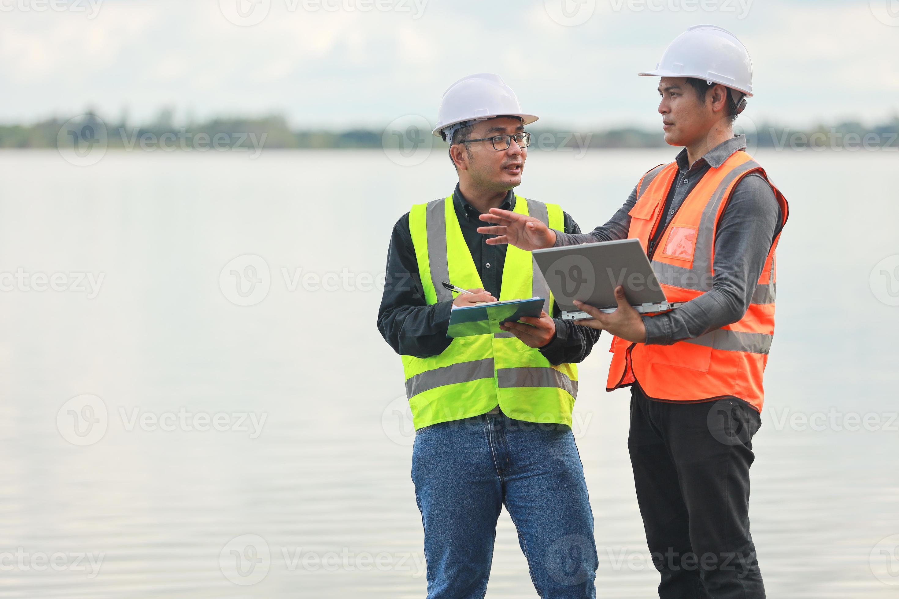 Environmental engineers work at water source to check for contaminants ...