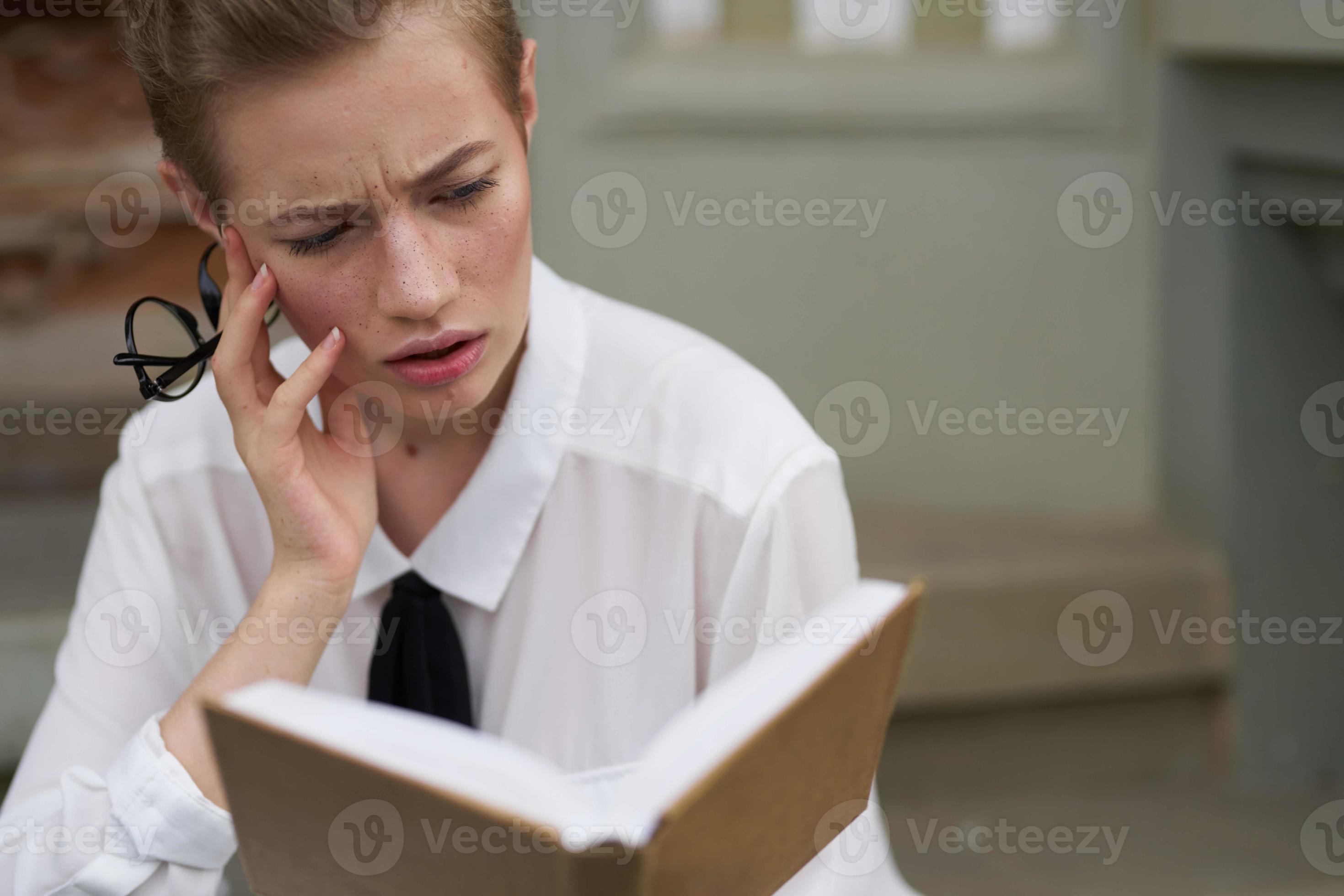short haired woman with a book in his hands outdoors reading Lifestyle ...