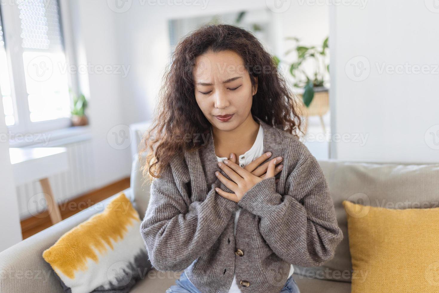 Stressed young woman feeling pain and touching chest suffer from ...