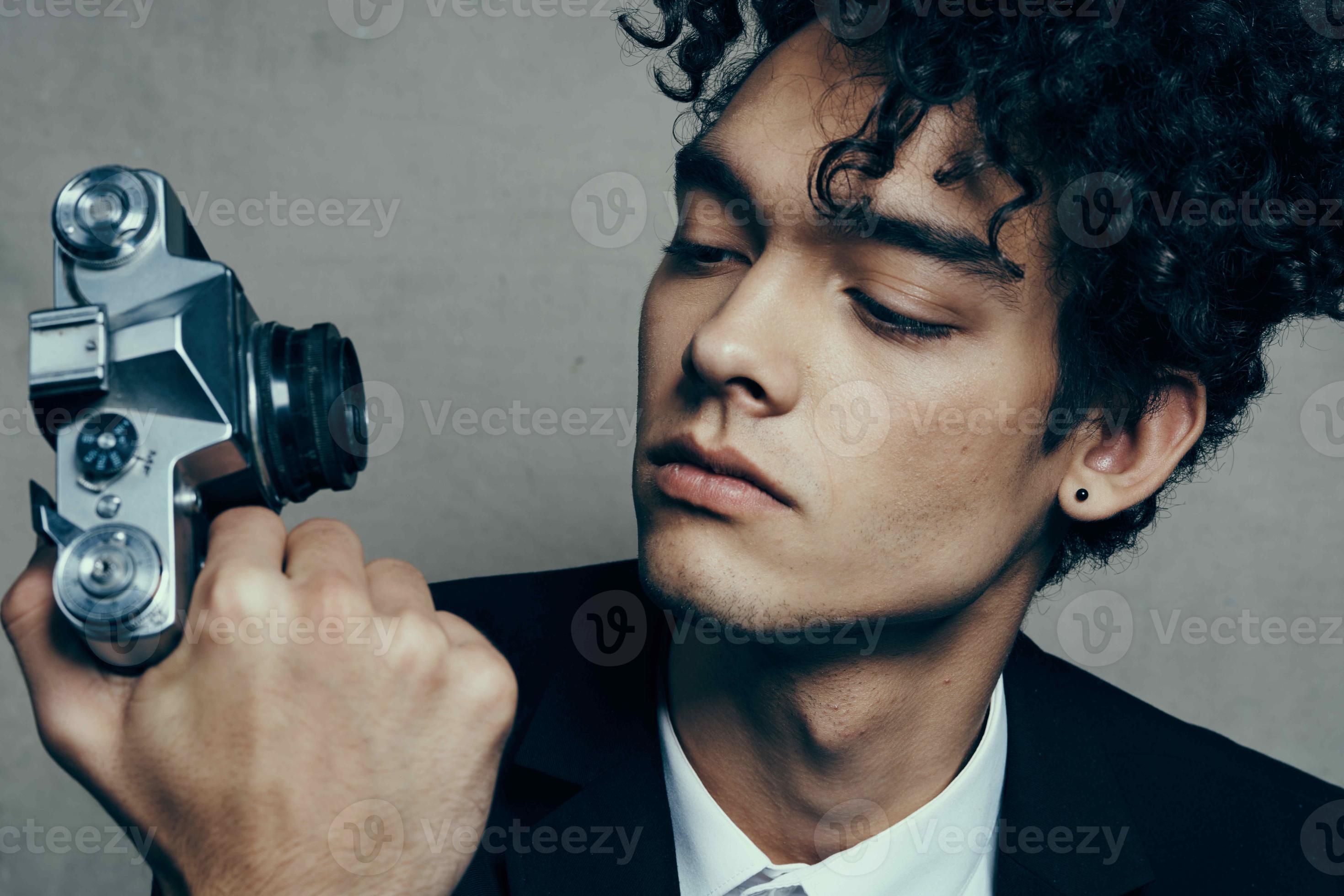 cute guy with curly hair with a camera in his hands photographer ...