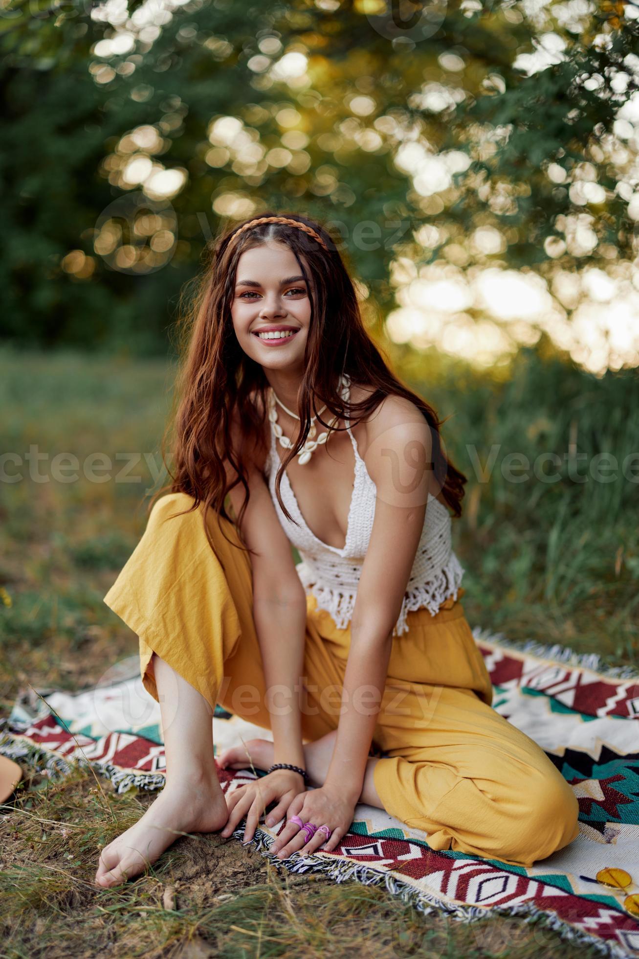 A Young Beautiful Hippie Woman Sits On The Ground In The Fall In Eco Clothing In The Sunset