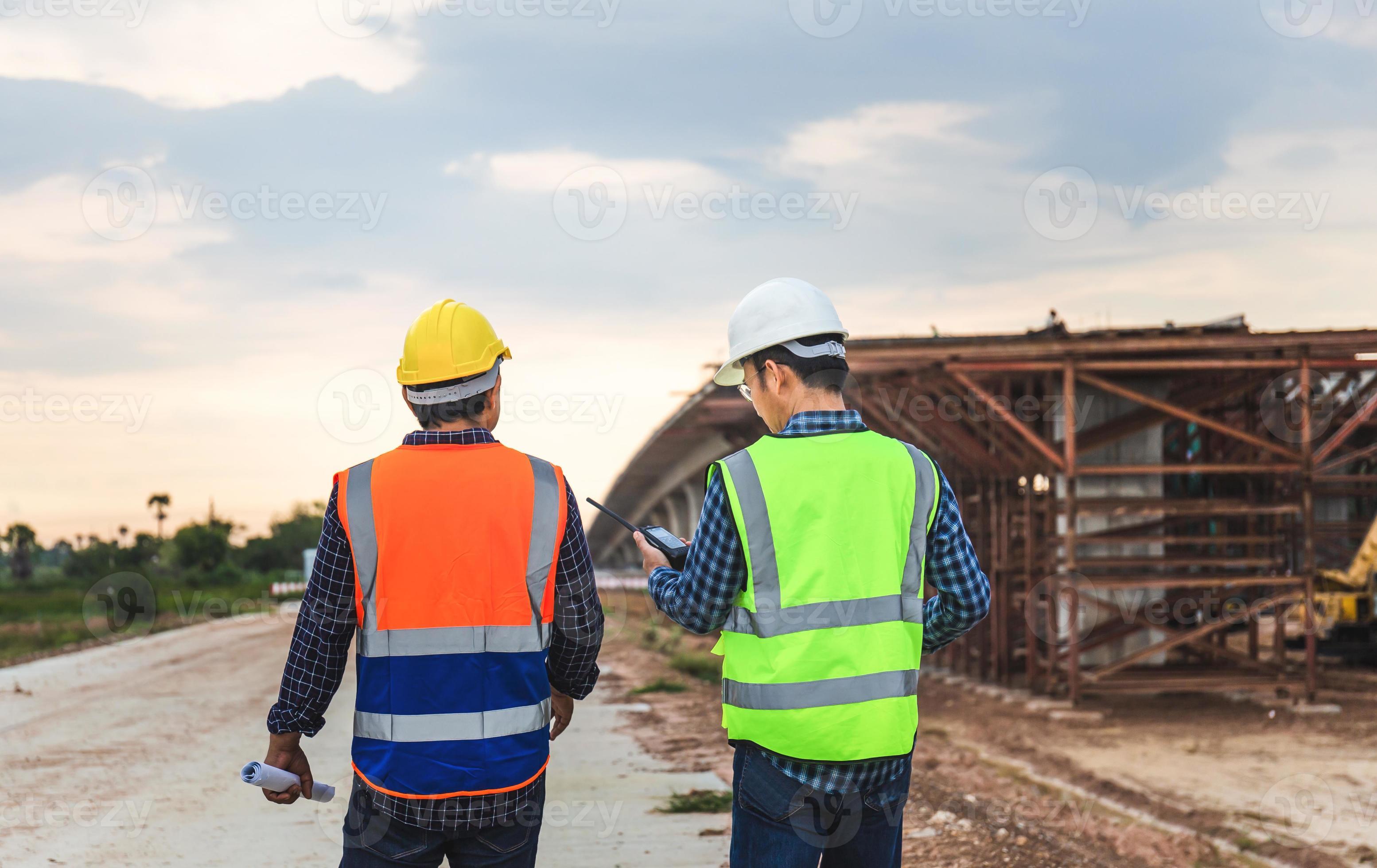Engineer and builders in hardhats discussing on construction site, Engineer and foreman worker ...