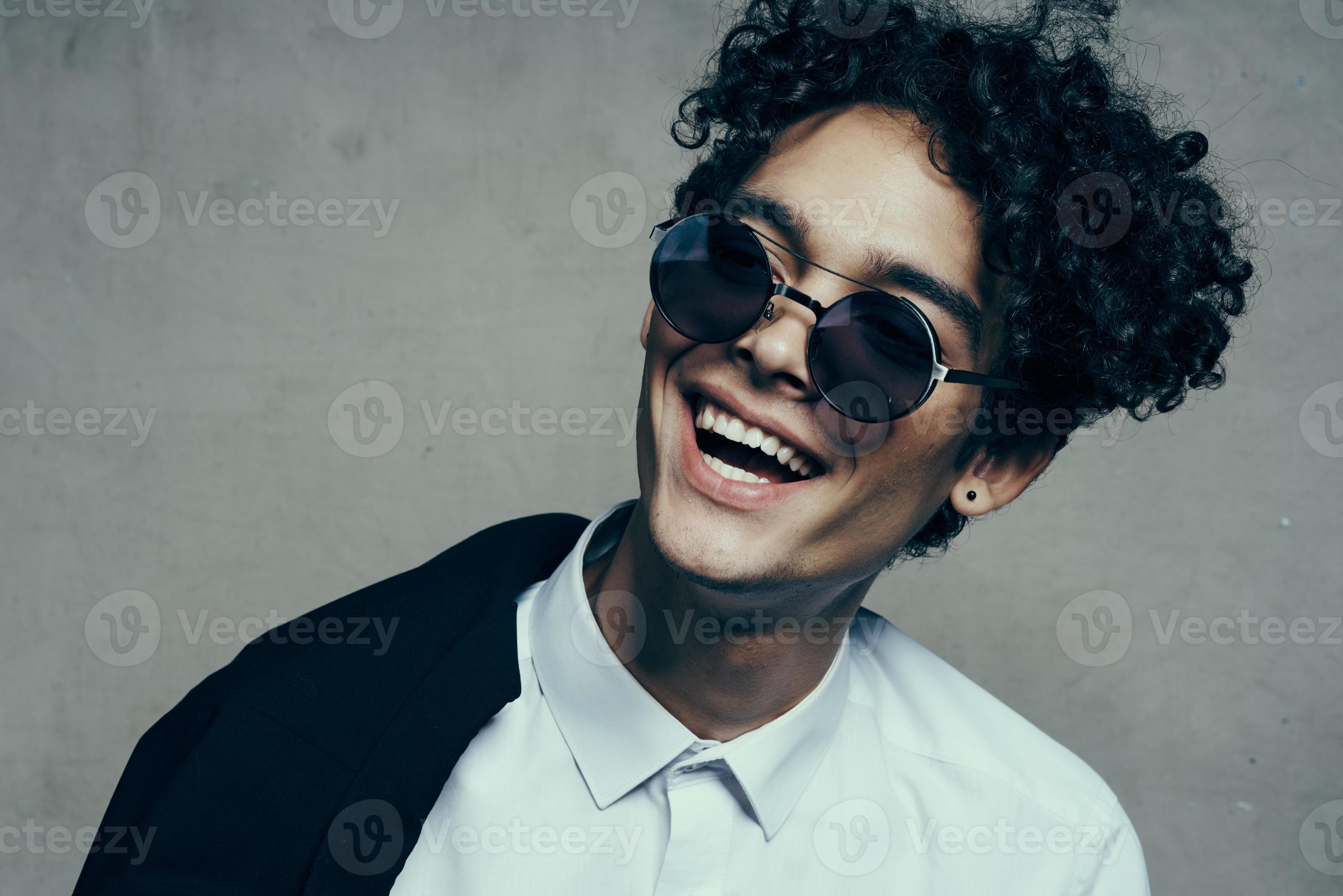 happy guy with glasses curly hair smile model teen gray background ...