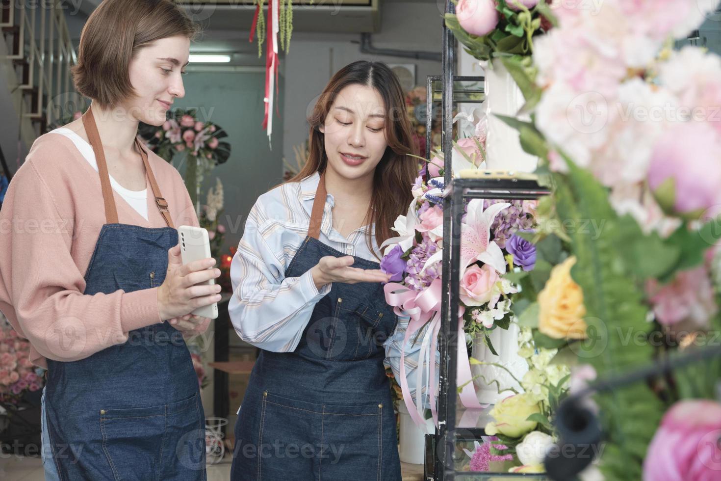 dos joven hermosa hembra florista socios tomar encantador flora manojo arreglo fotos por móvil ...