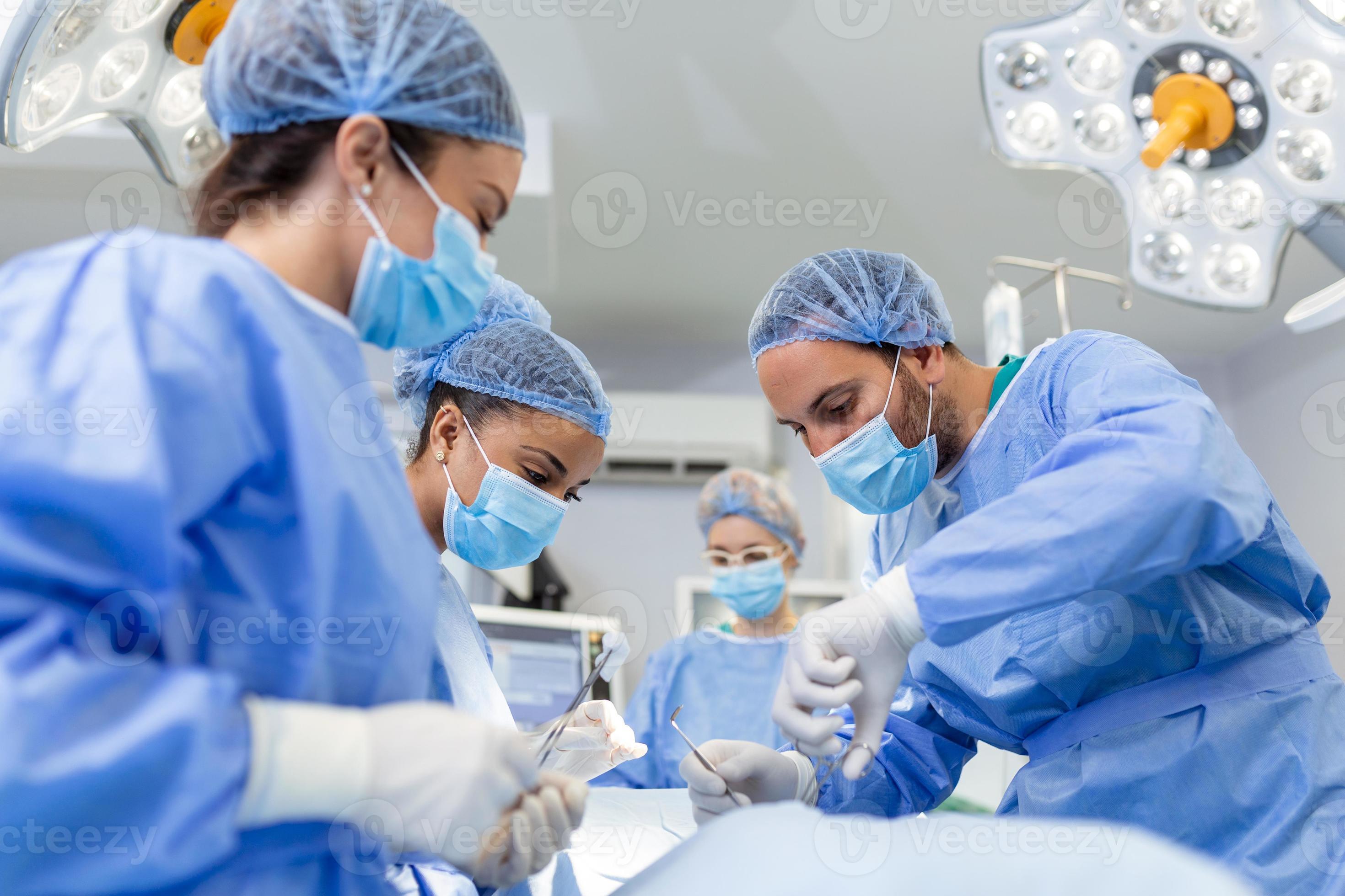 Surgery operation. Group of surgeons in operating room with surgery equipment. Medical ...