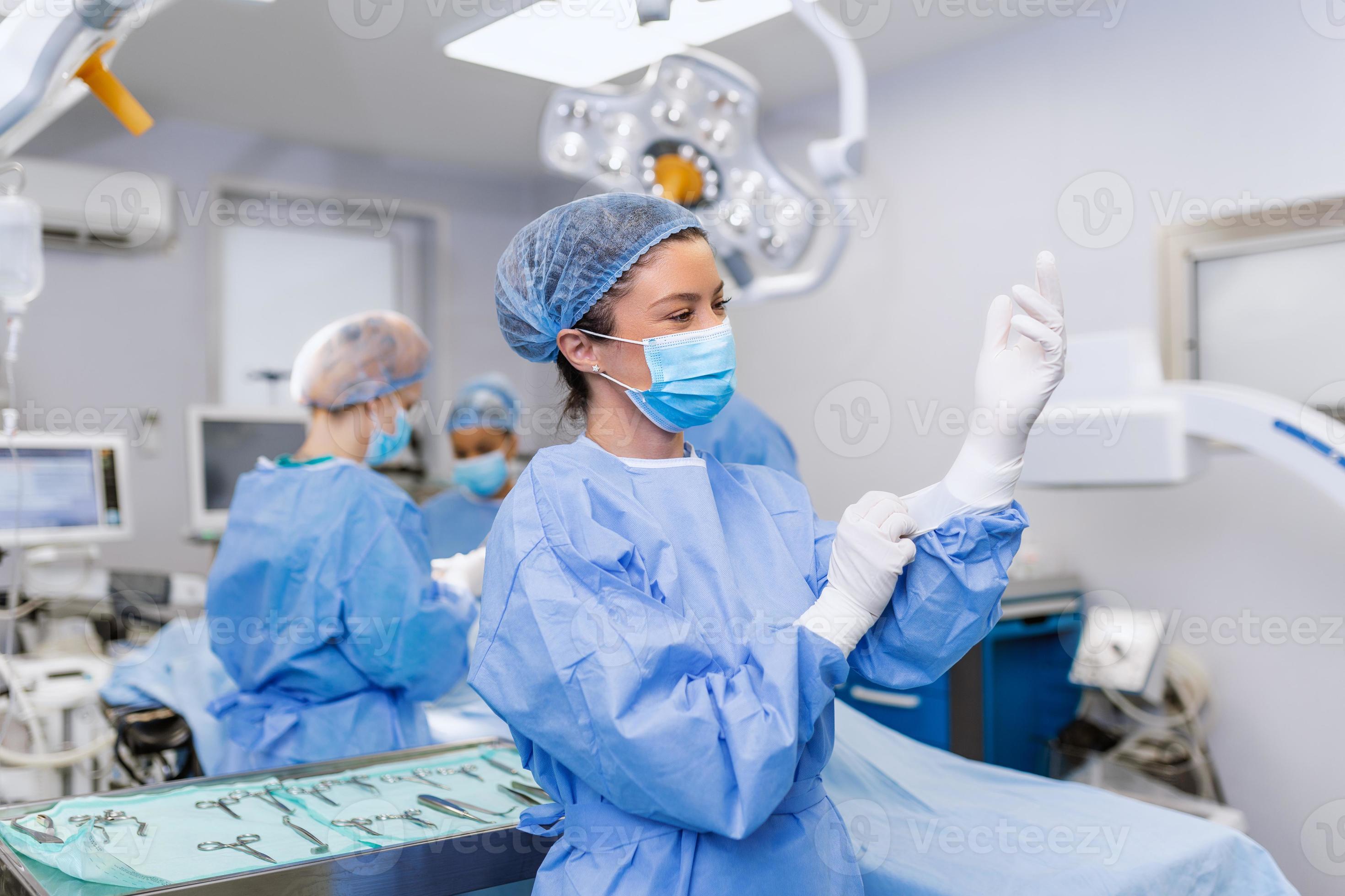 Portrait Of Beautiful Female Doctor Surgeon Putting On Medical Gloves
