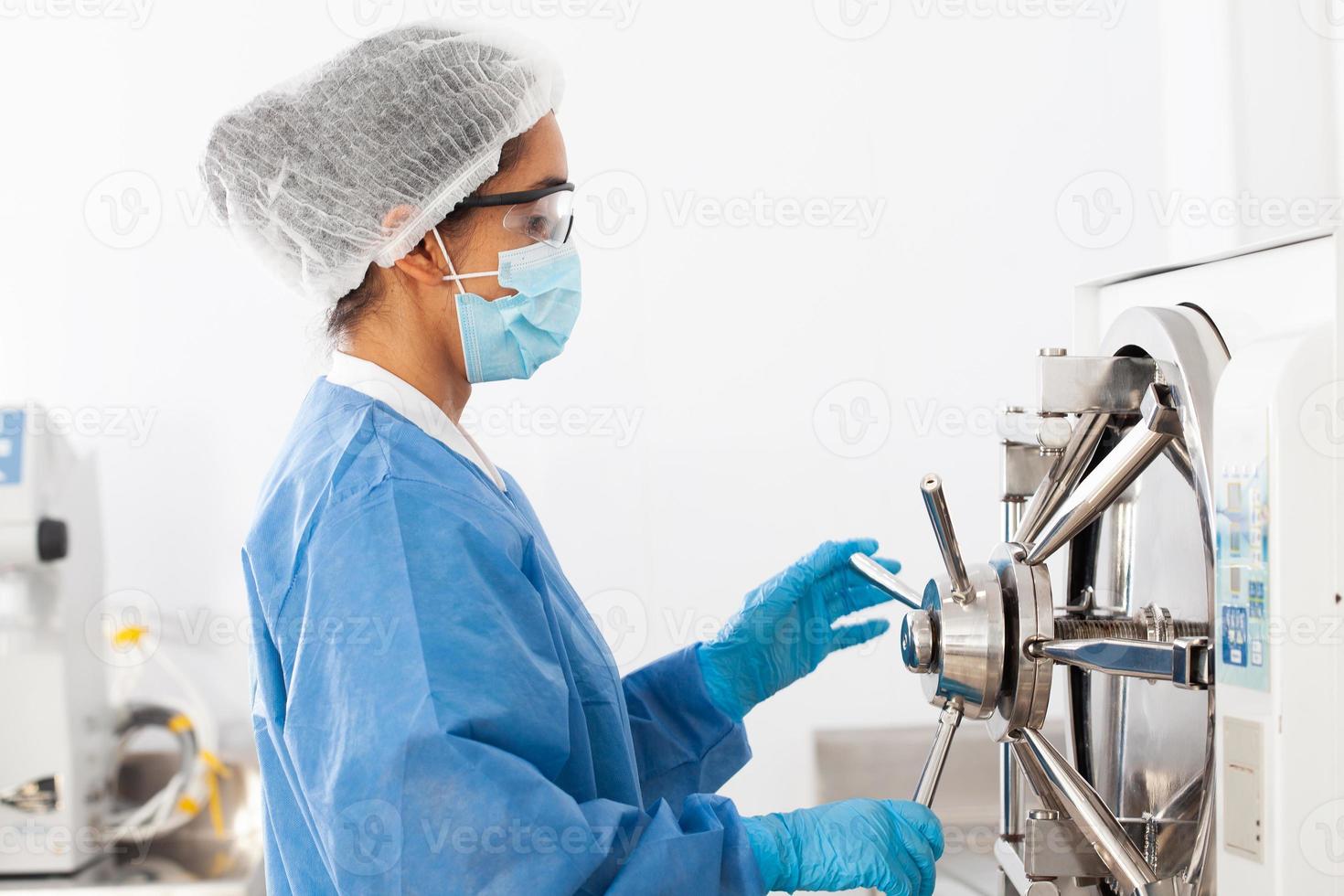 Young female scientist sterilizing laboratory material in autoclave 22750735 Stock Photo at Vecteezy