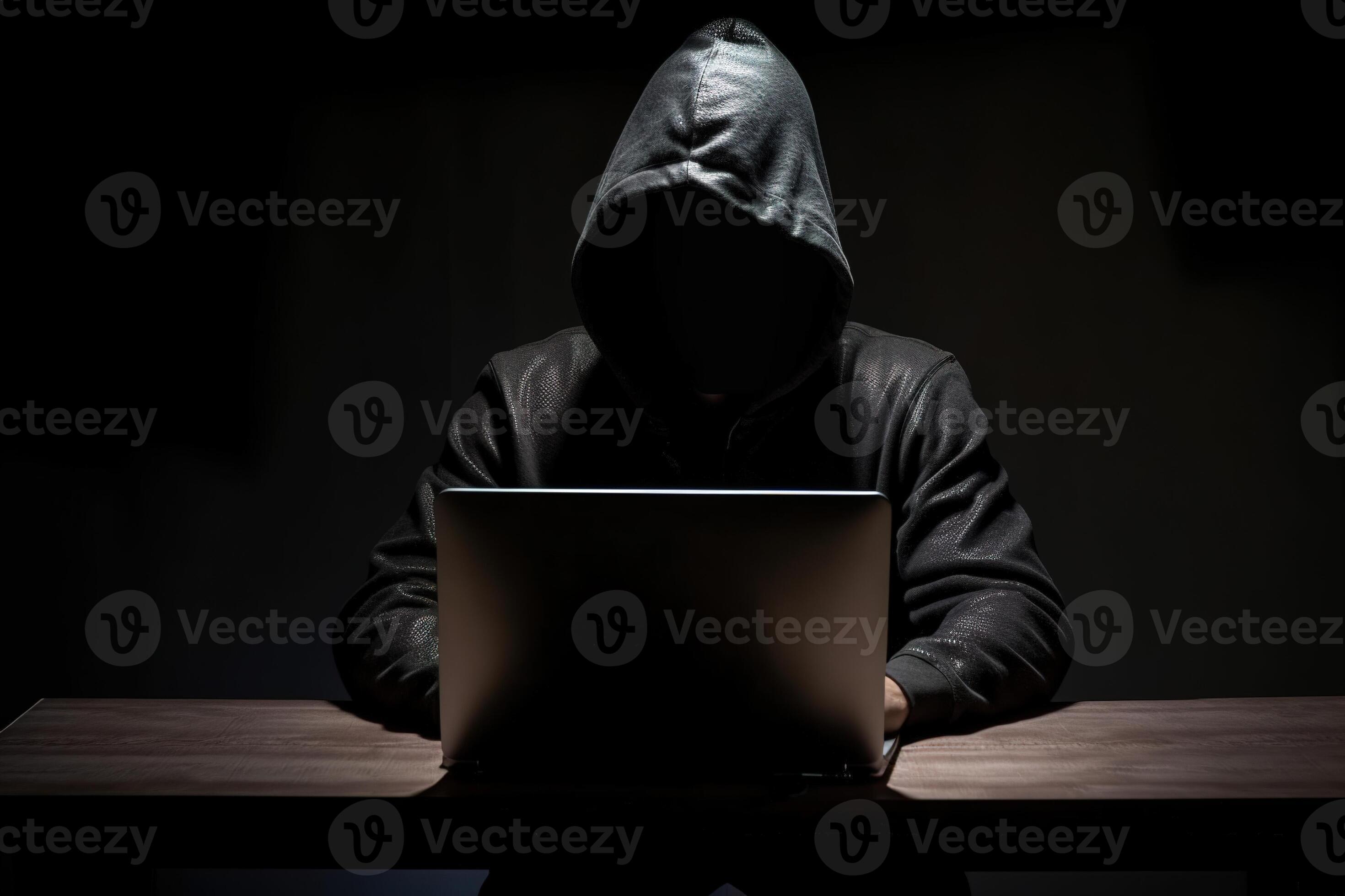 Hacker Wearing Black Hoodie Using Laptop Computer While Working On Dark