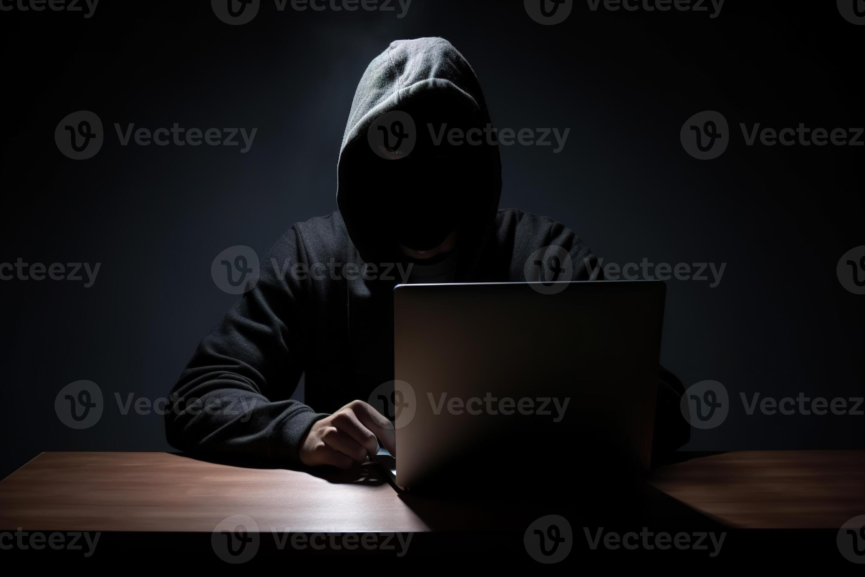 Hacker Wearing Black Hoodie Using Laptop Computer While Working On Dark