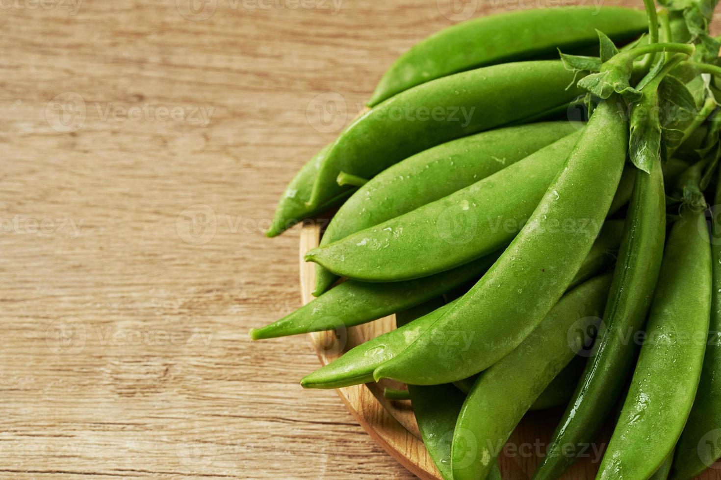 food concept fresh green pea pod in wooden plate on wood background ...