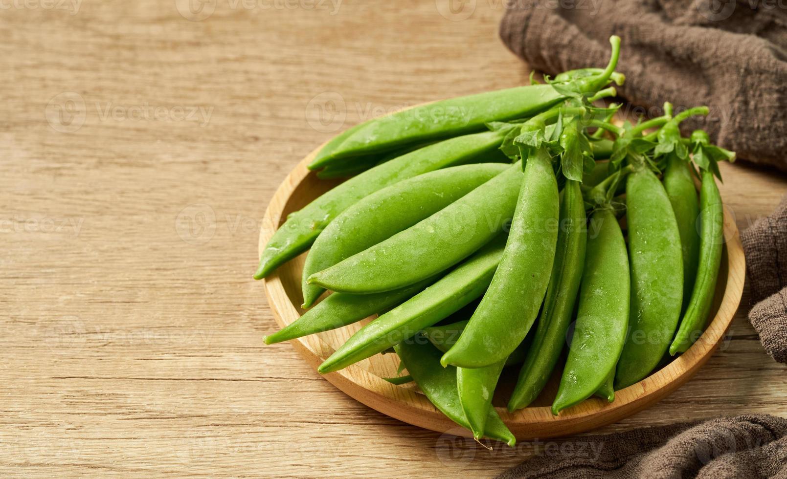 food concept fresh green pea pod in wooden plate on wood background ...