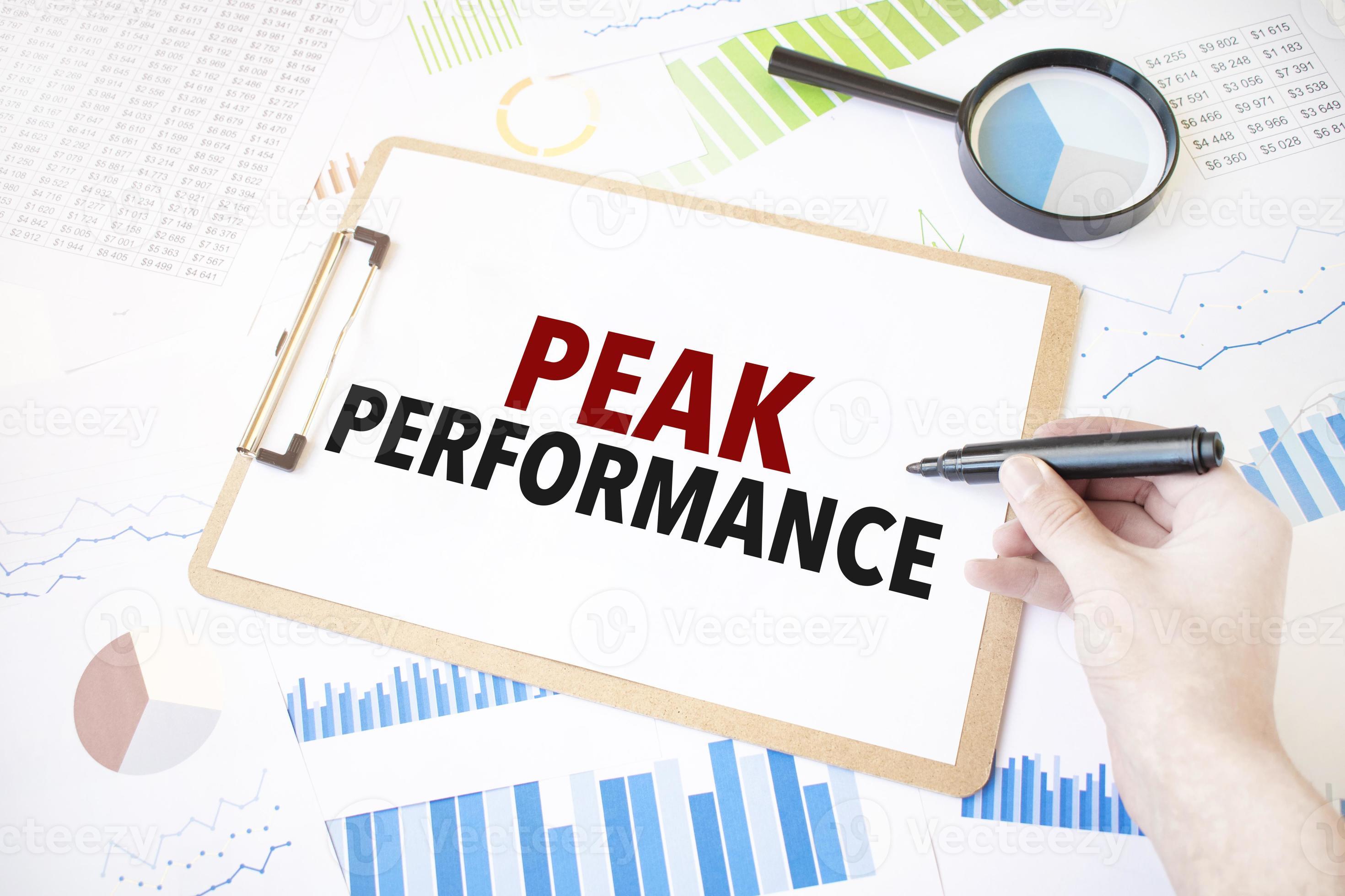 Text peak performance on white paper sheet and marker on businessman ...