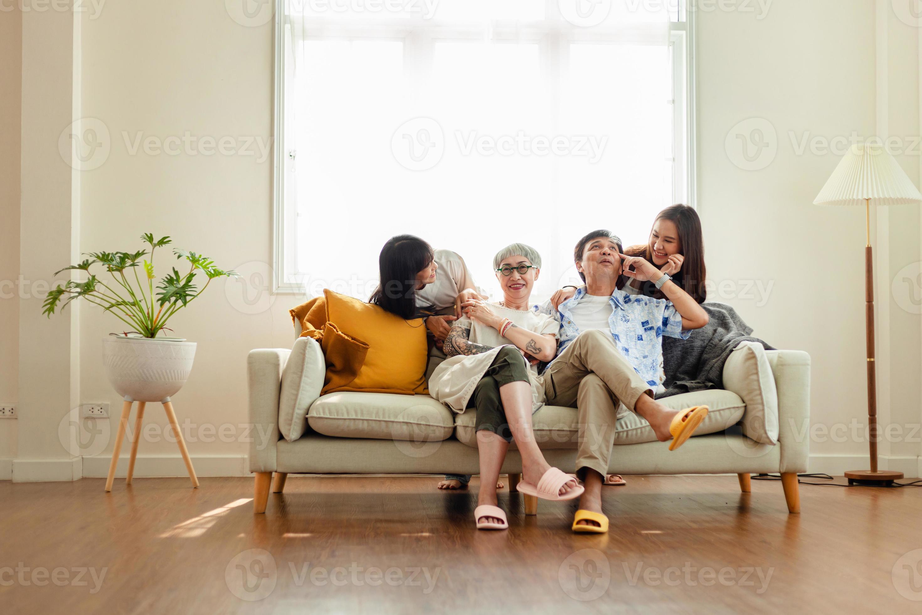 happy family Asian family, parents and children Happy sitting on the sofa in the house. The ...