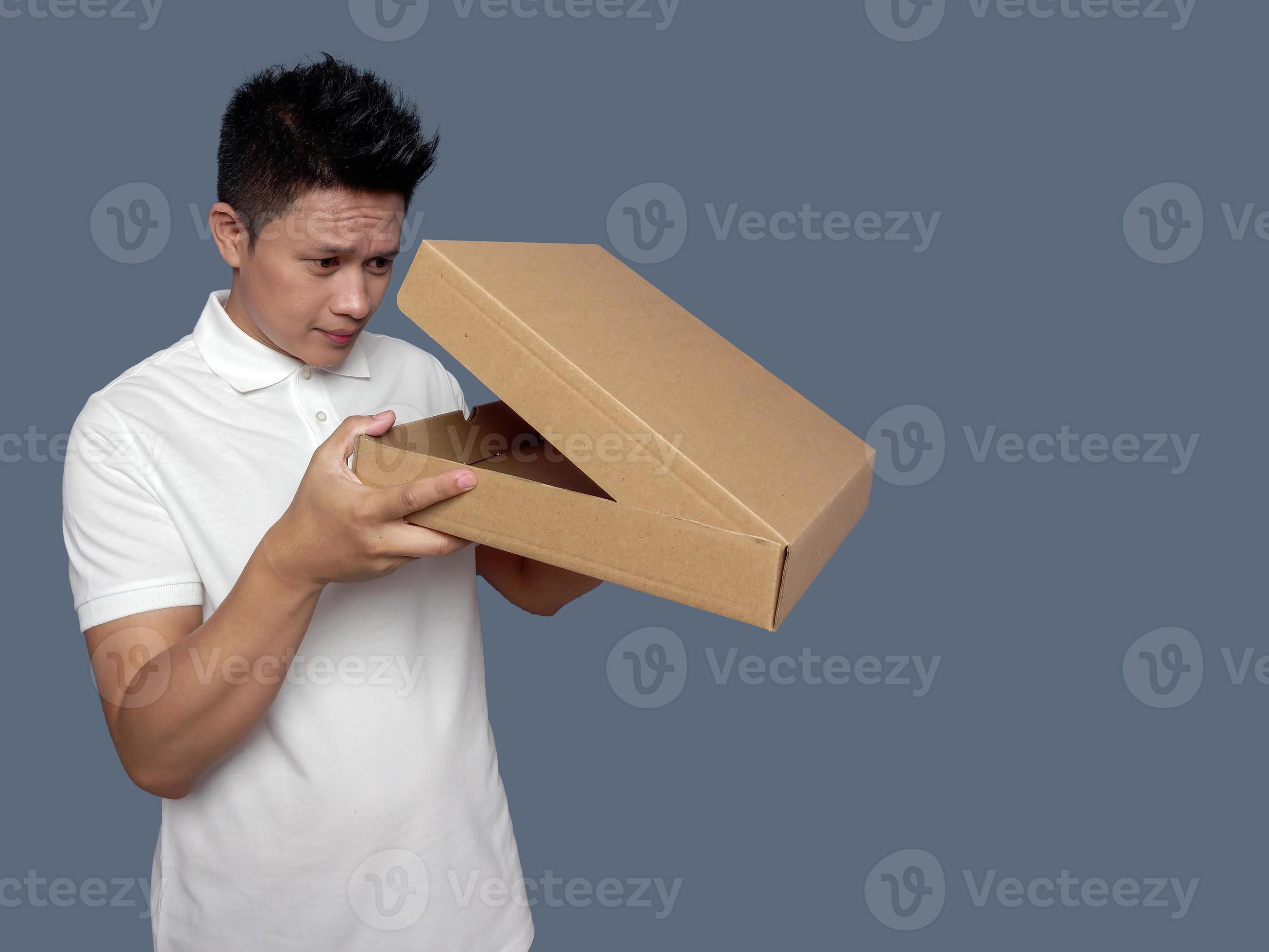 Man opening and peeking inside the cardboard box isolated on plain background 22992901 Stock ...