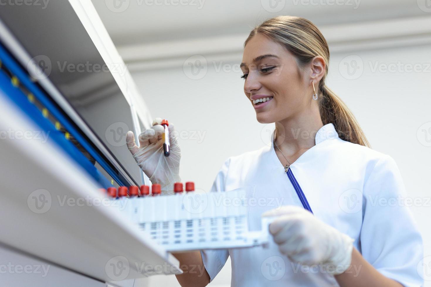 Lab tech loading samples into a chemistry analyzer. female lab tech ...