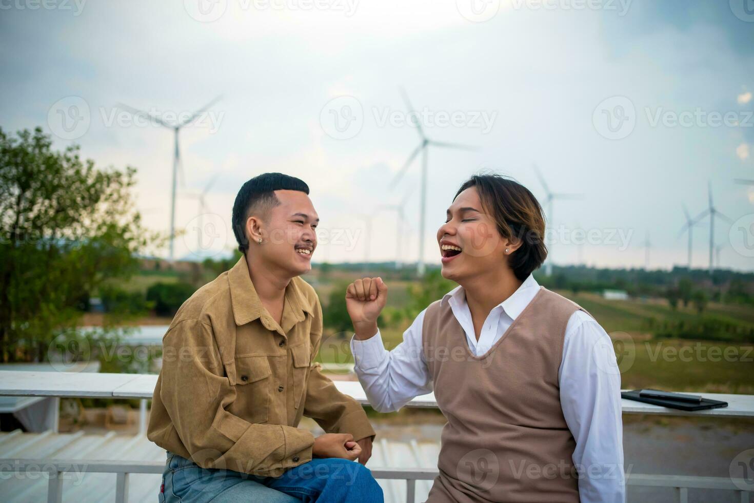 Group of two LGBTQ friends sitting and talking laughing happy on the roof of the coffee shop ...