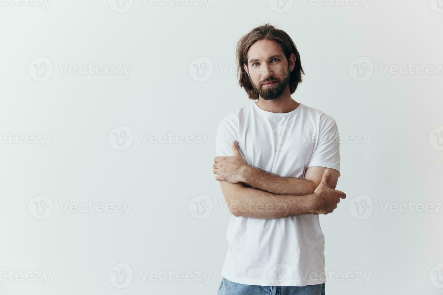 Portrait of a man with a black thick beard and long hair in a white T ...