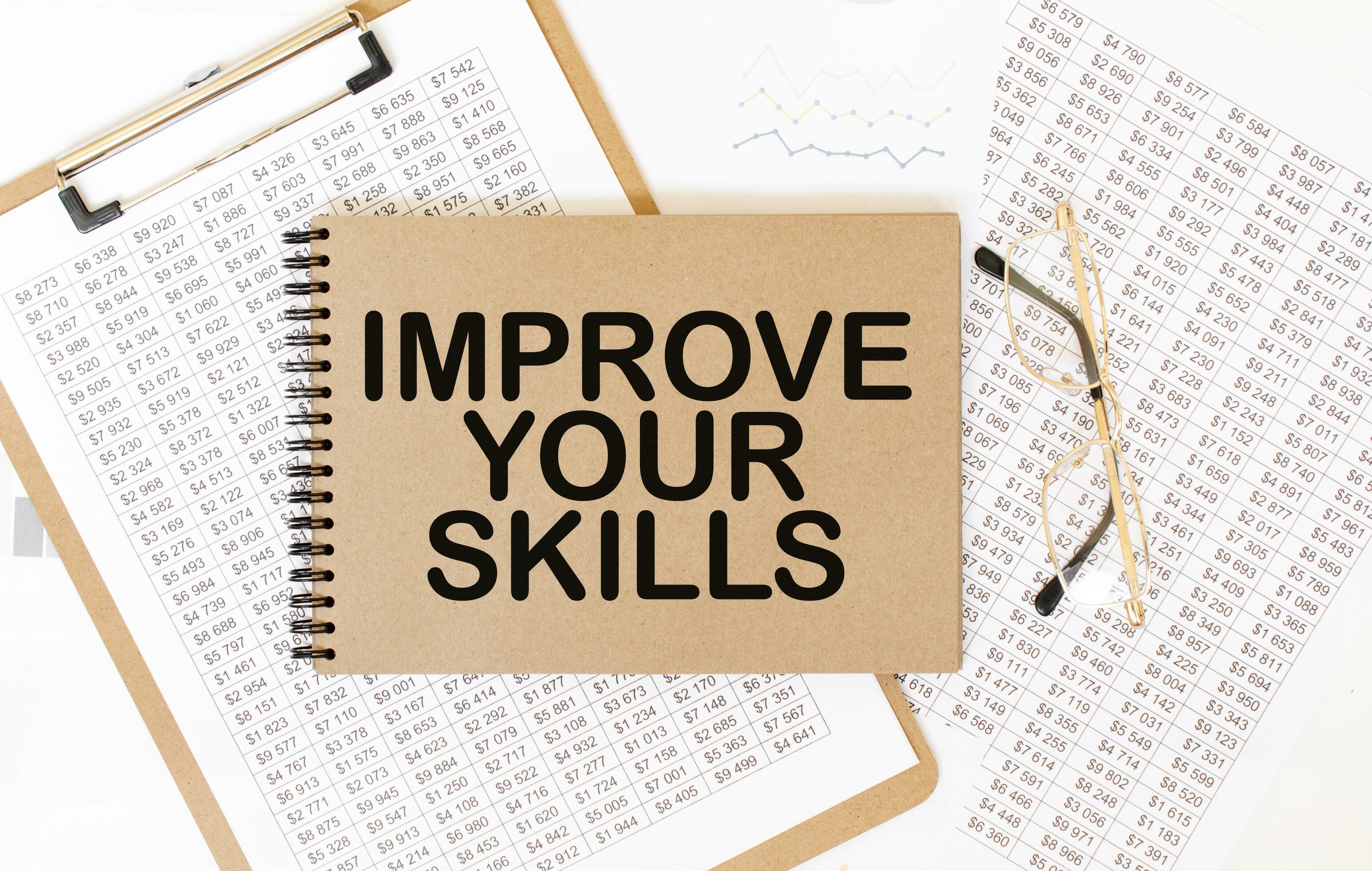 Craft colour notepad with text IMPROVE YOUR SKILLS. Notepad with eyeglasses and text documents ...