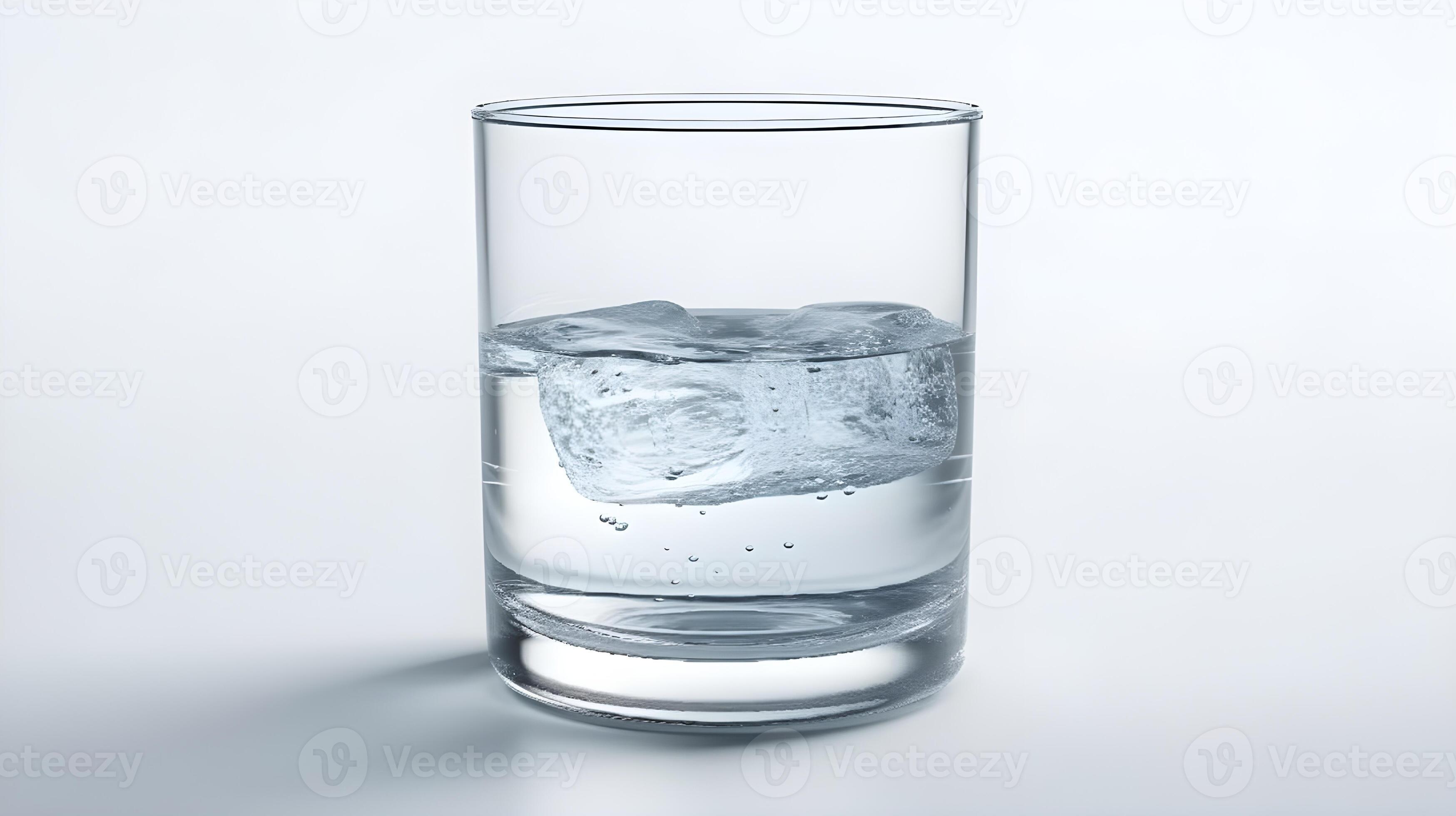 a glass of mineral water with ice cube half full isolated on white background studio shot ...