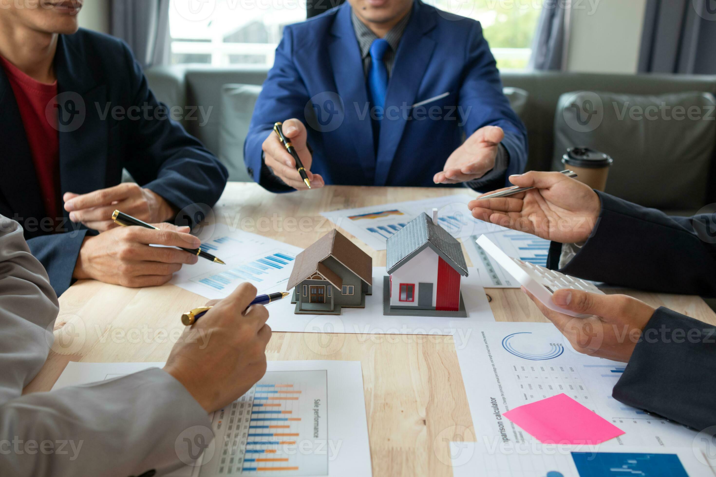 Real estate sales documents and model homes are placed on tables inside real estate sales ...