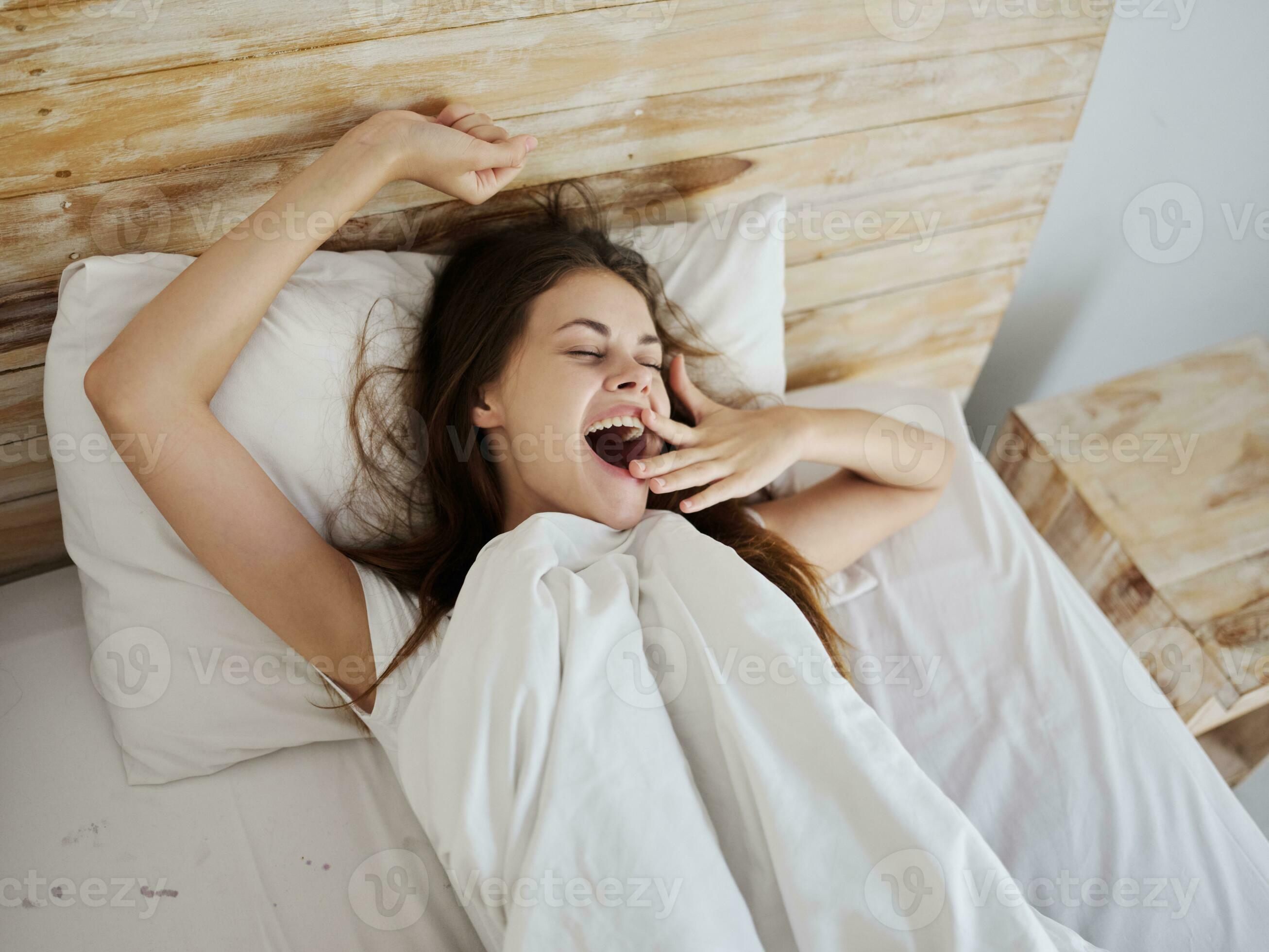 woman lying in bed waking up after sleep yawning good morning 23614401 Stock Photo at Vecteezy