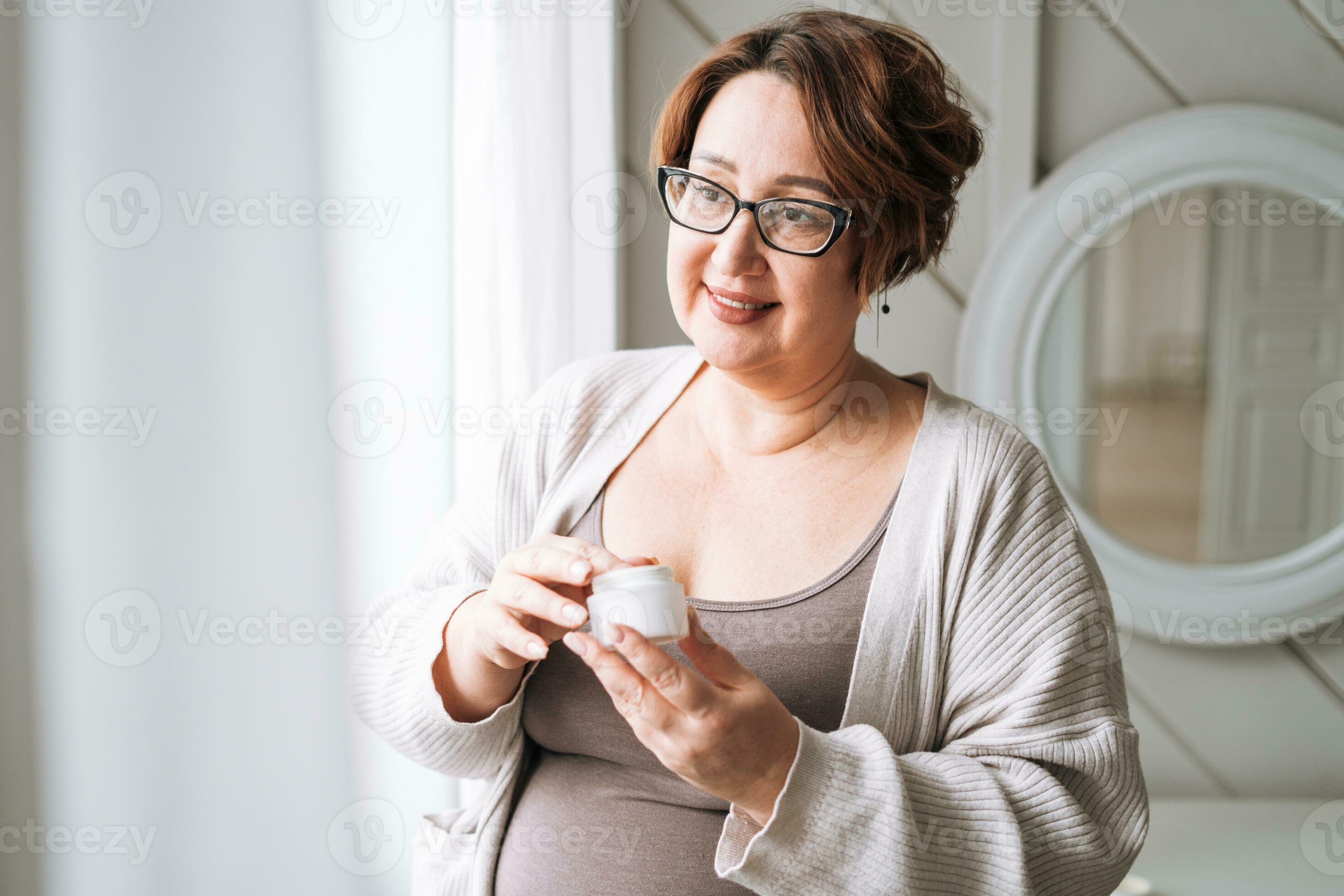 Smiling middle aged plus size woman with day cream near window at home 23740949 Stock Photo at ...