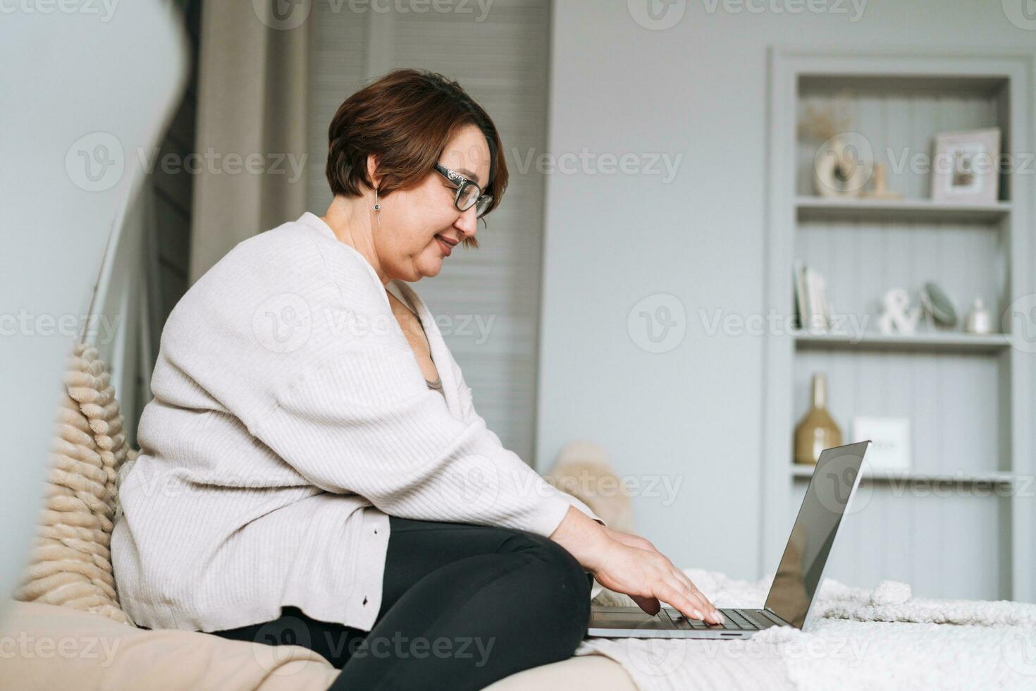 Smiling middle aged plus size woman working on laptop from home 23740954 Stock Photo at Vecteezy