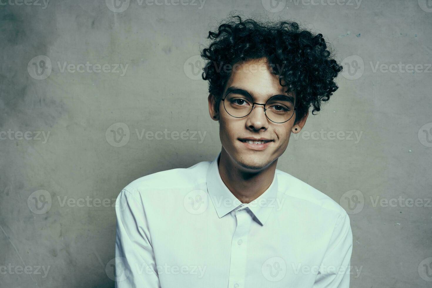 portrait of a happy guy with glasses curly hair white shirt photoshoot ...