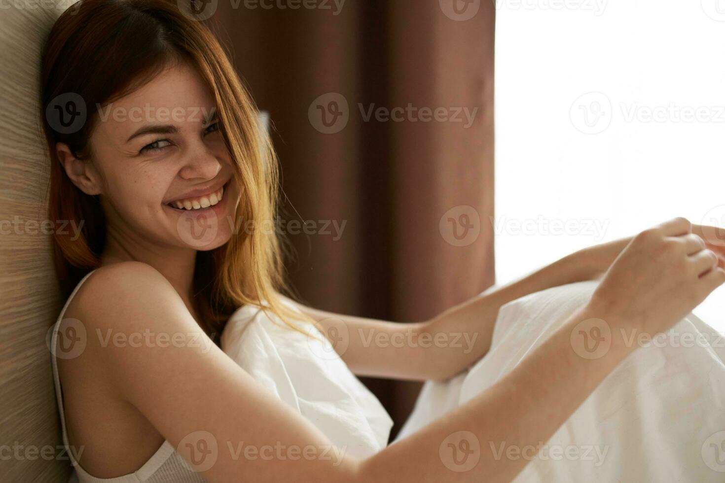 Emotional Woman Lies In Bed Under The Covers And Gestures With Her