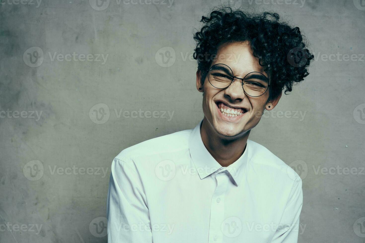 portrait of a happy guy with glasses curly hair white shirt photoshoot ...