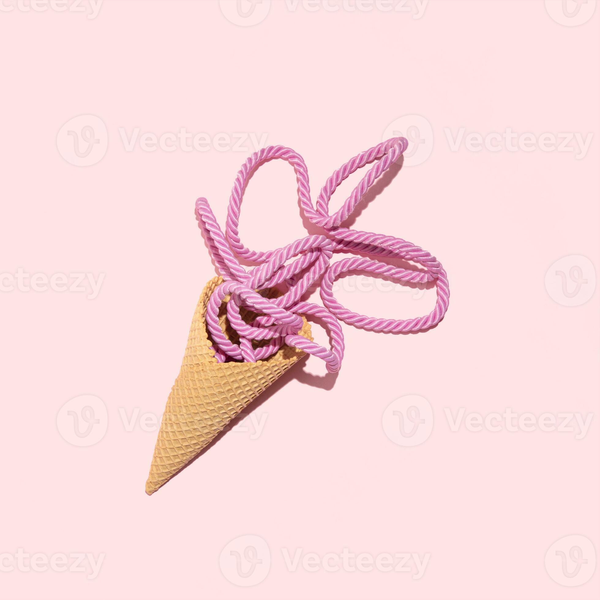 Pastel pink fabric cord in an ice cream cone, creative summer holiday concept, melting fruit ...